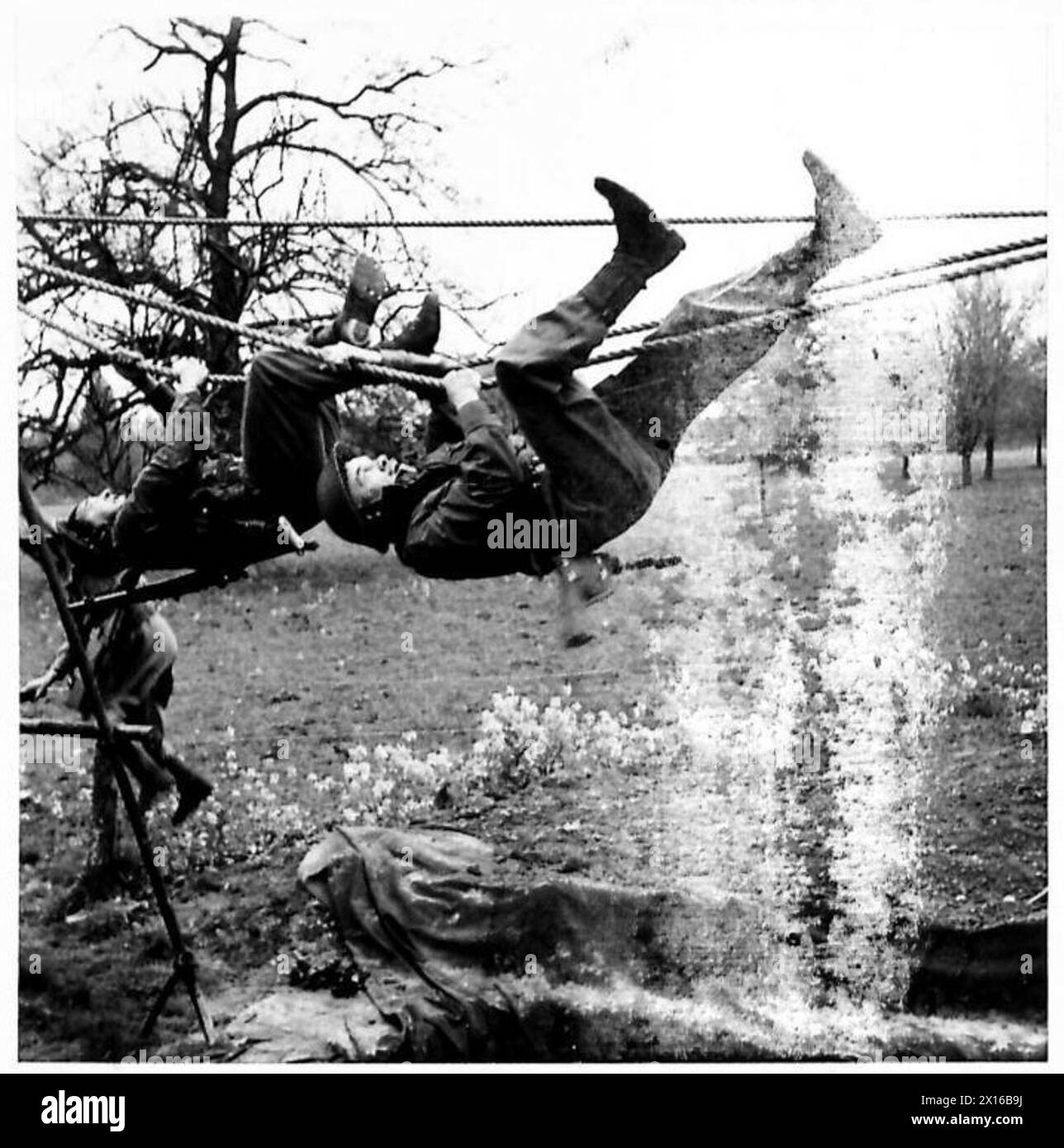 Participants cross a rope bridge over a stream during a British Army ...