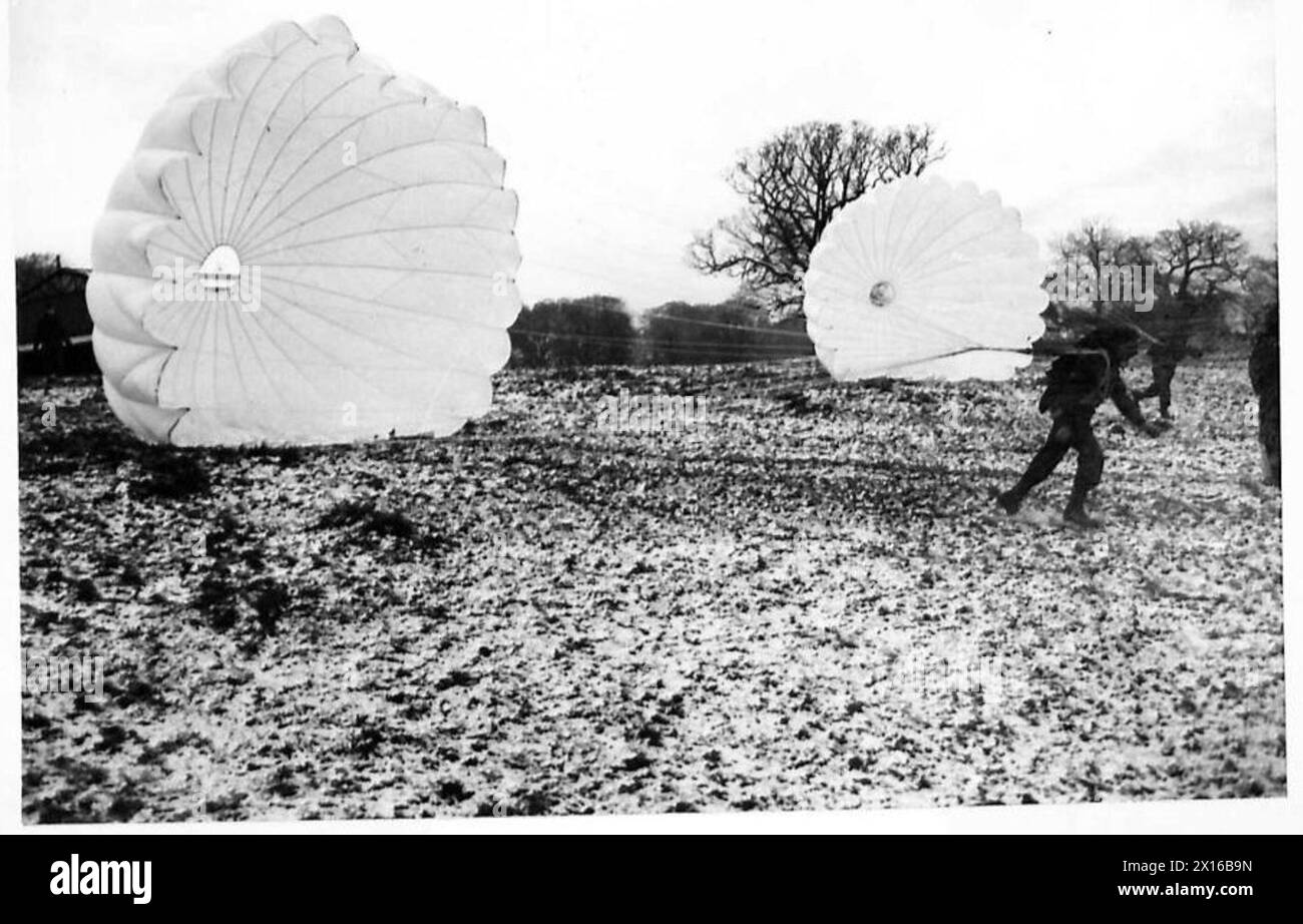 Parachute troops conduct training on the ground with their parachutes ...