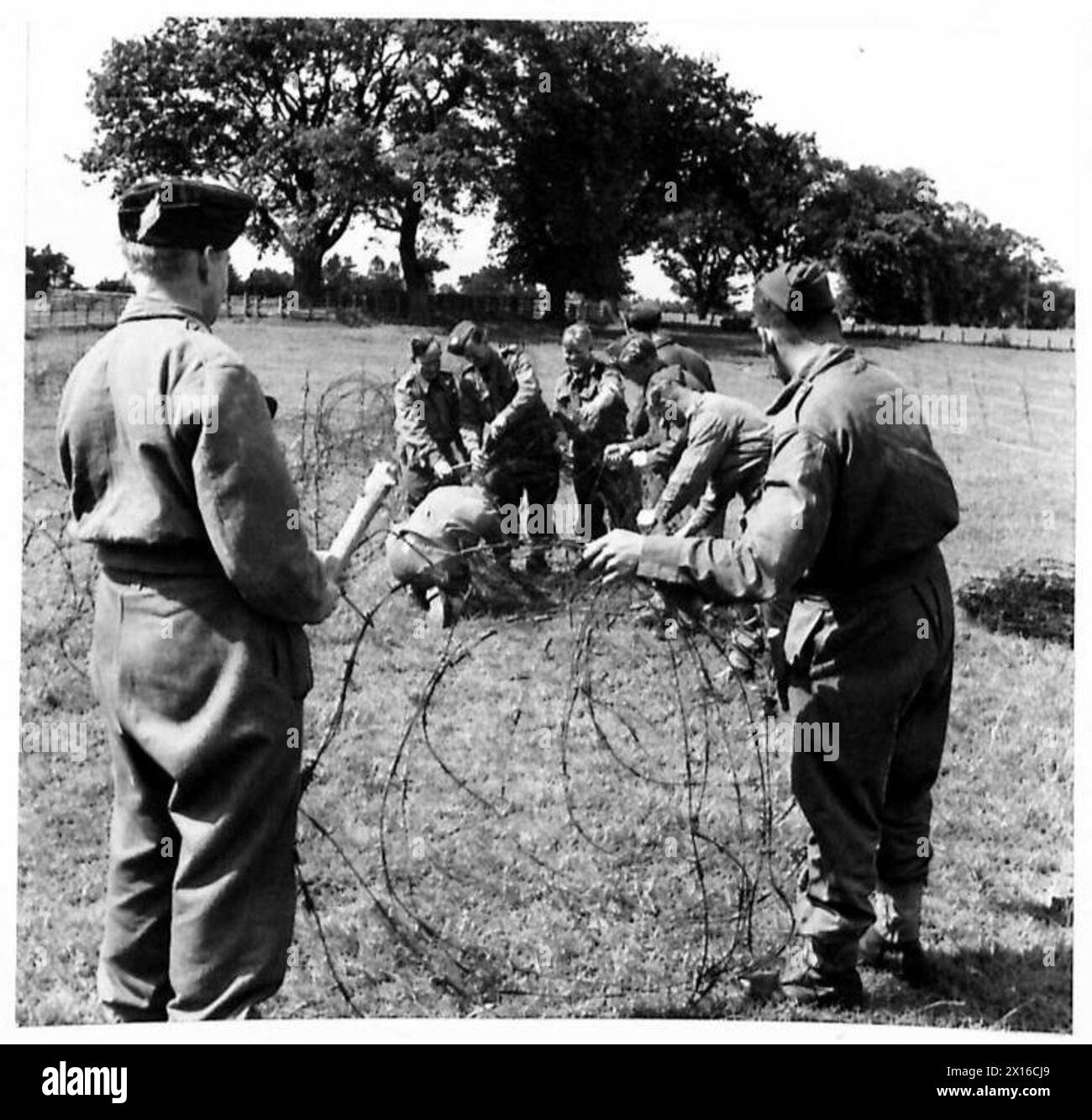 R.A.F. LAYING TRIPLE CONCERTINA DANNERT WIRING - A third coil of ...