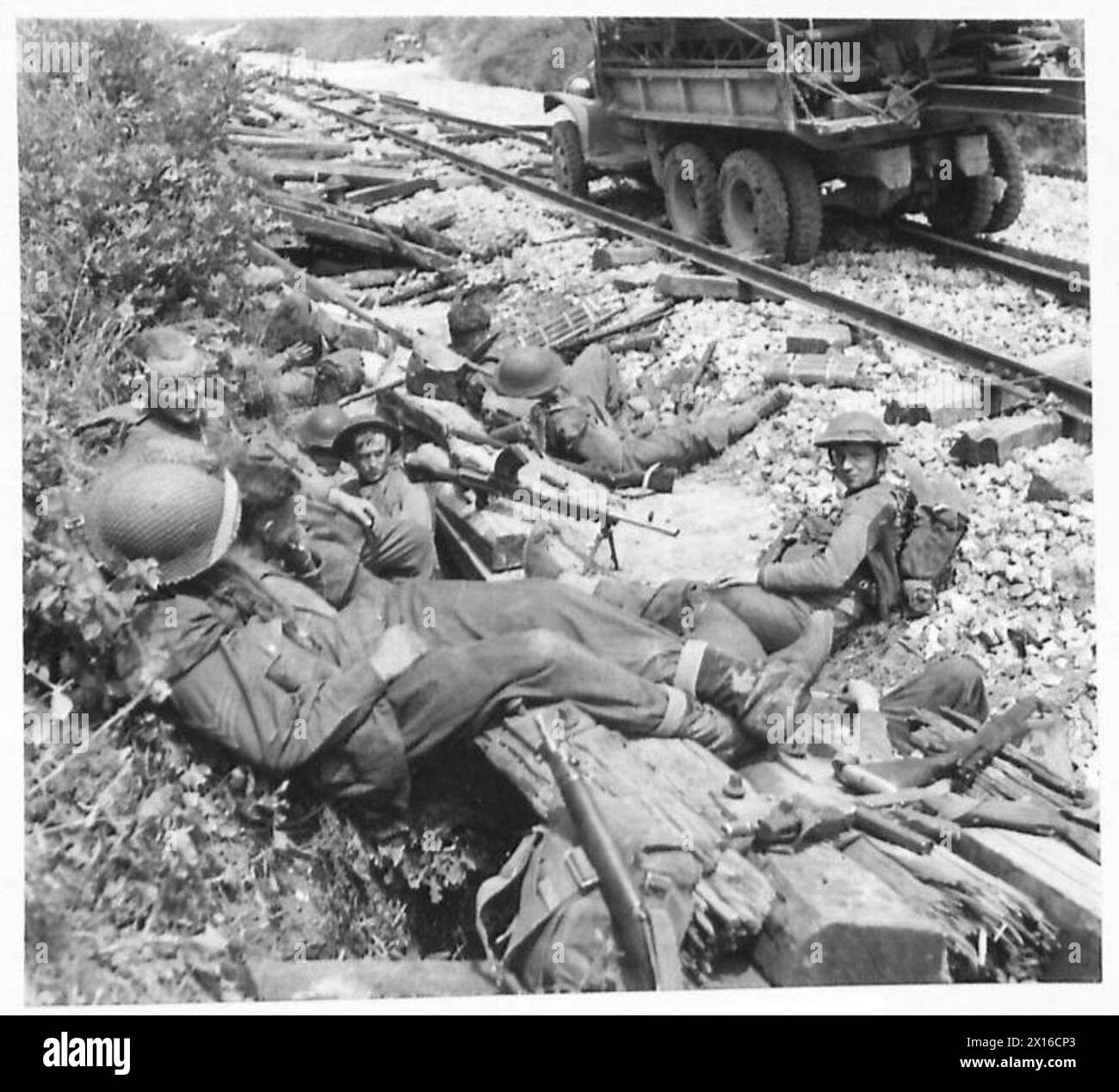 Infantrymen rest near a railroad while awaiting the order to cross a ...