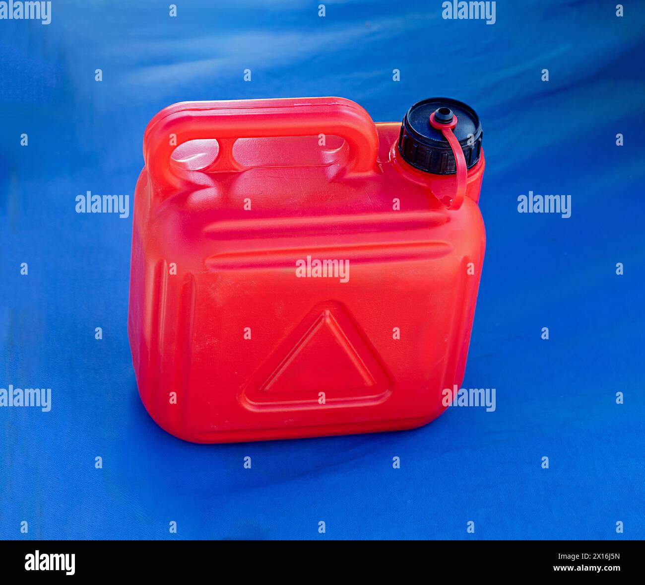 Red plastic closed container on a blue background Stock Photo - Alamy