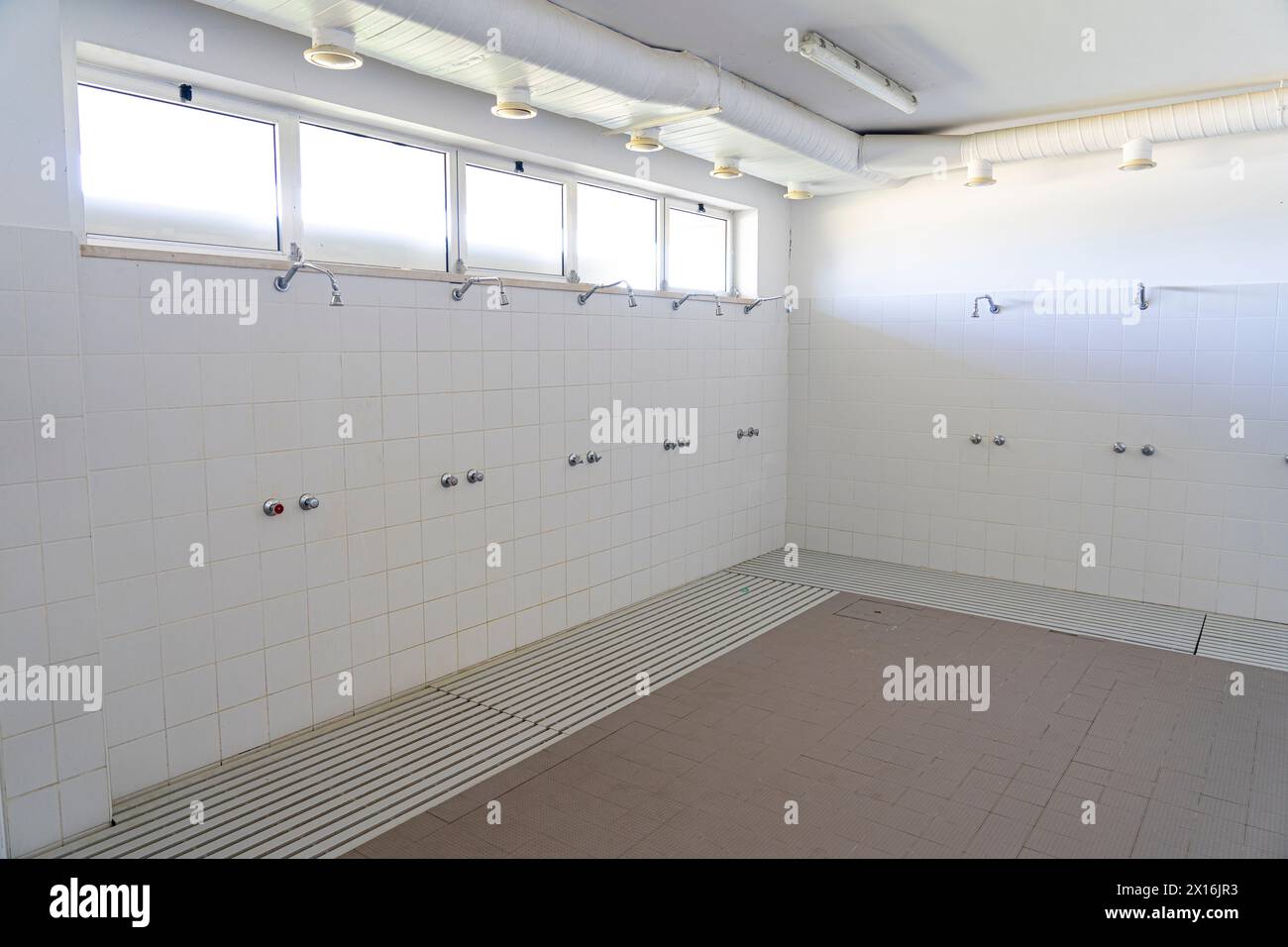 Changing rooms in the shower area with white tile wall Stock Photo - Alamy