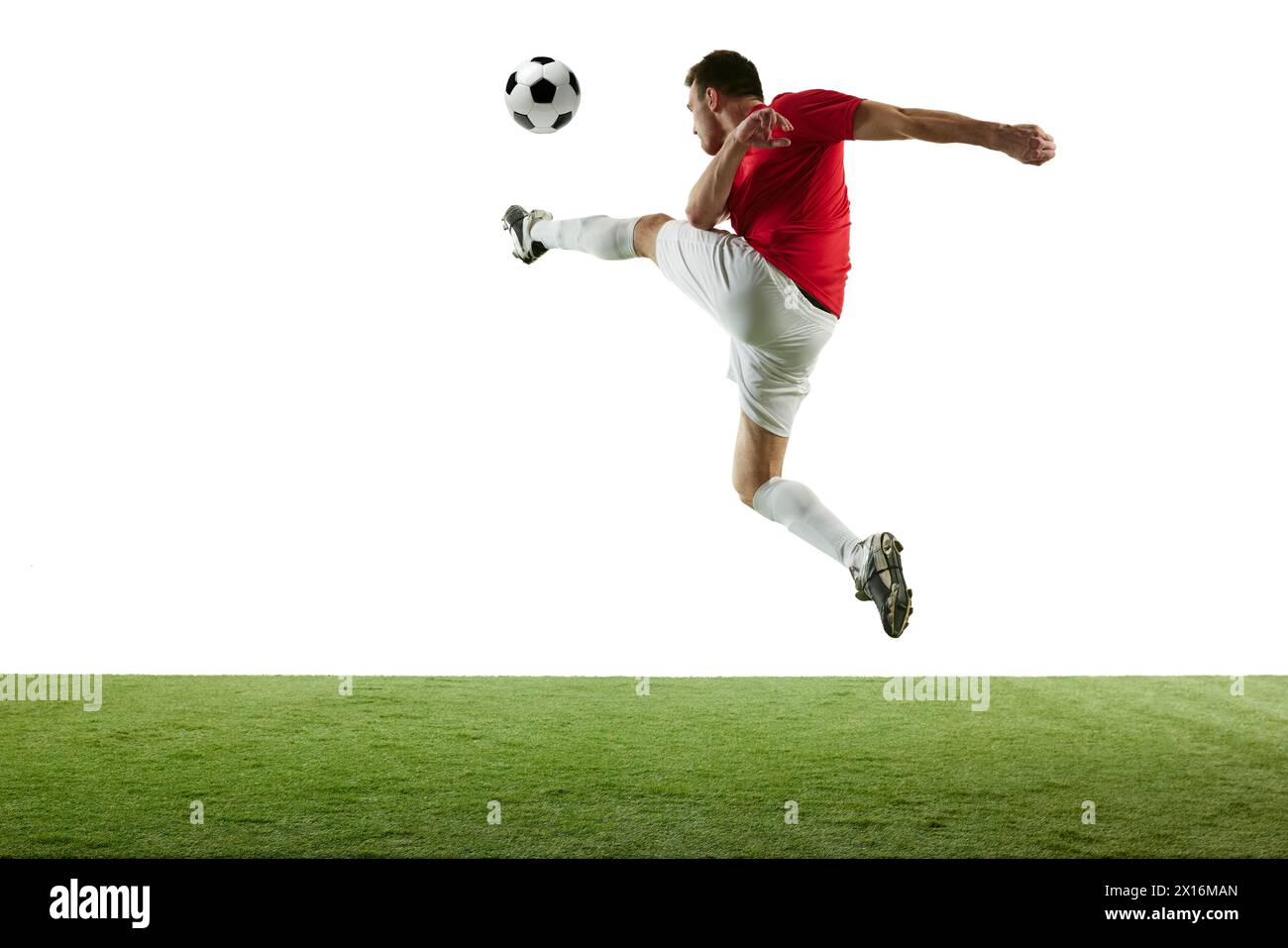 Motivated and competitive male football player hitting ball in jump ...