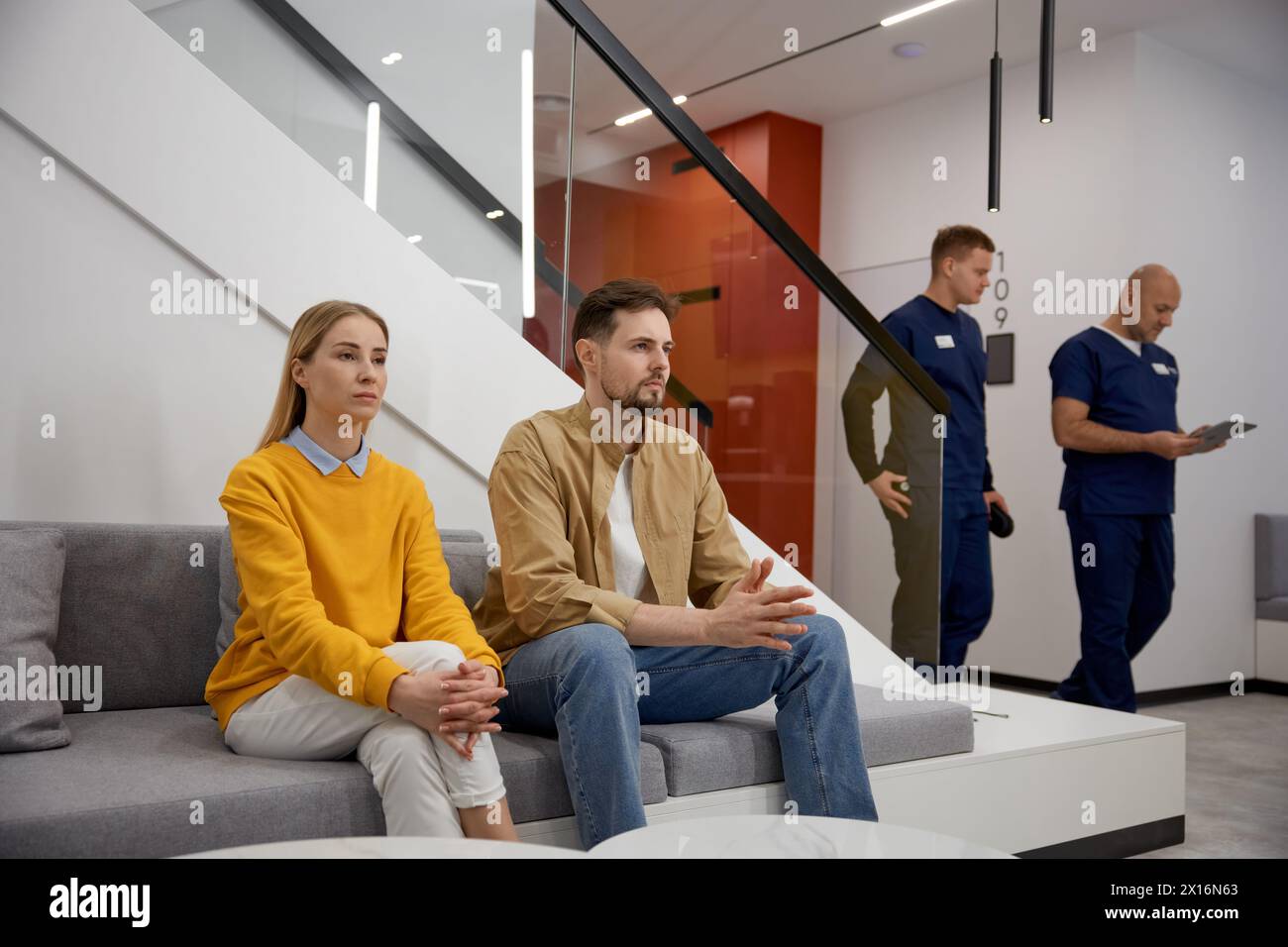Nervous man and woman couple patient waiting for appointment in hallway ...
