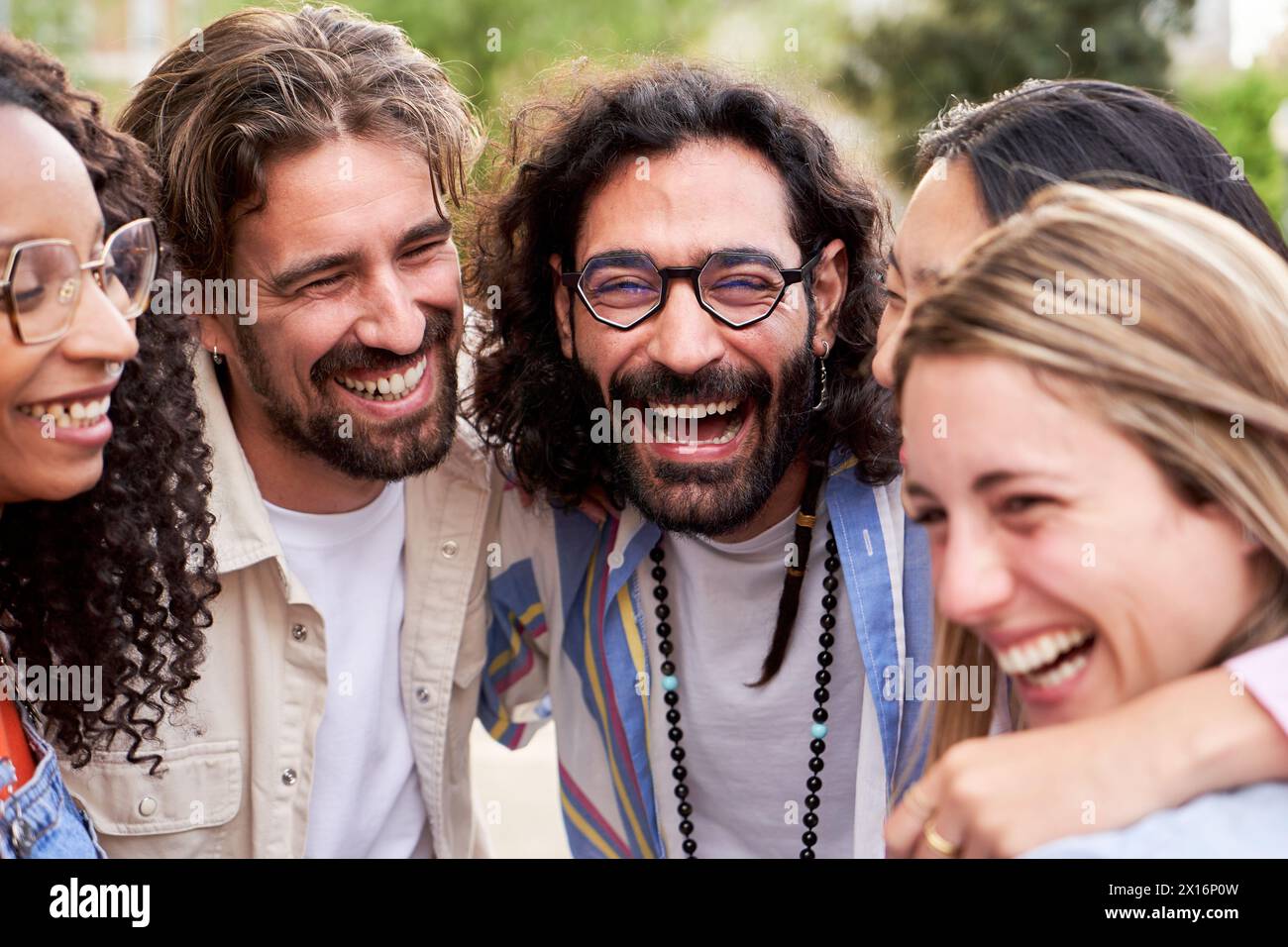 Headshot of a group of friends embraced laughing together having a good ...