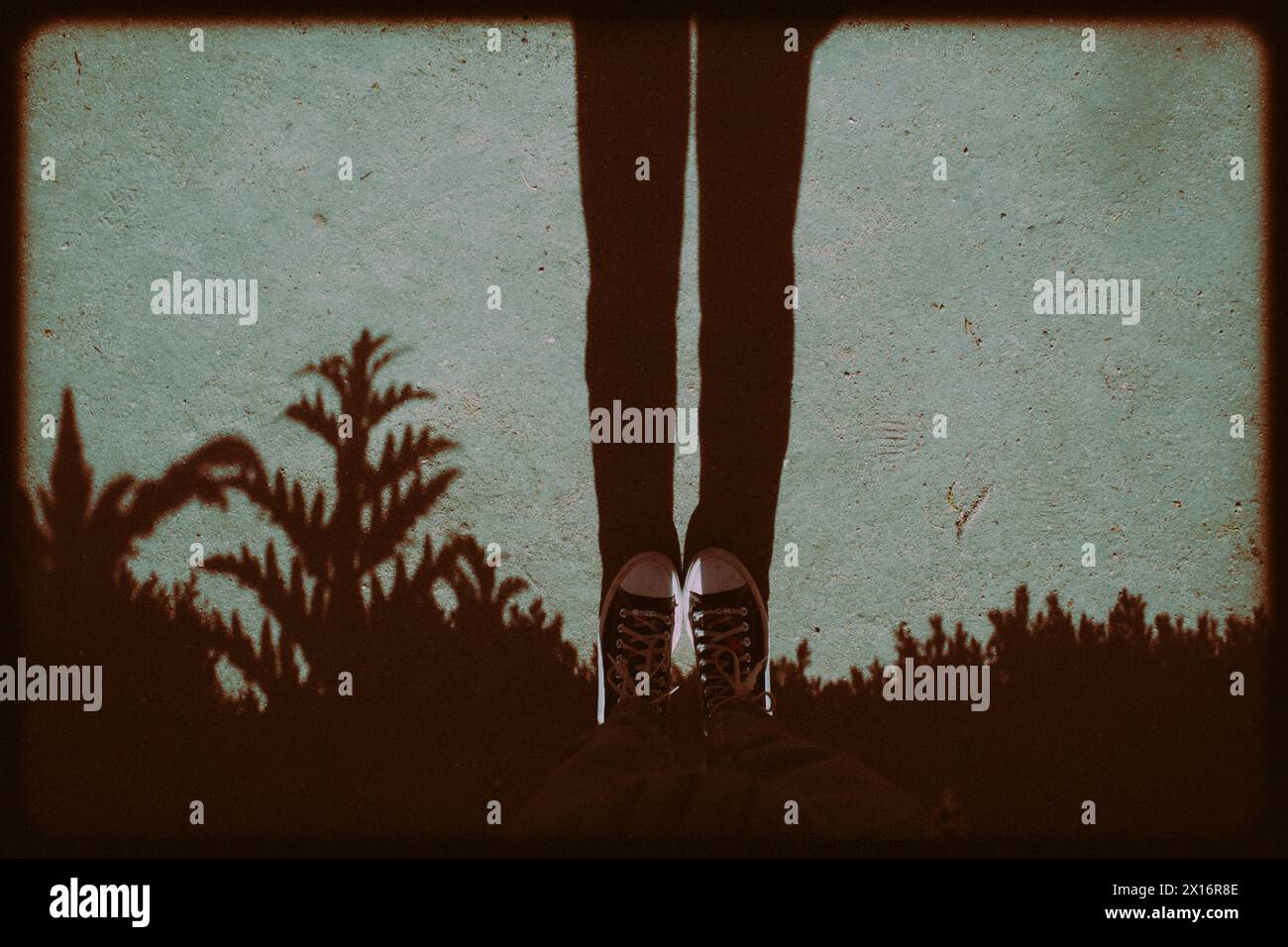 Female legs silhouette and contrasting shadow on ground surface. A walk ...