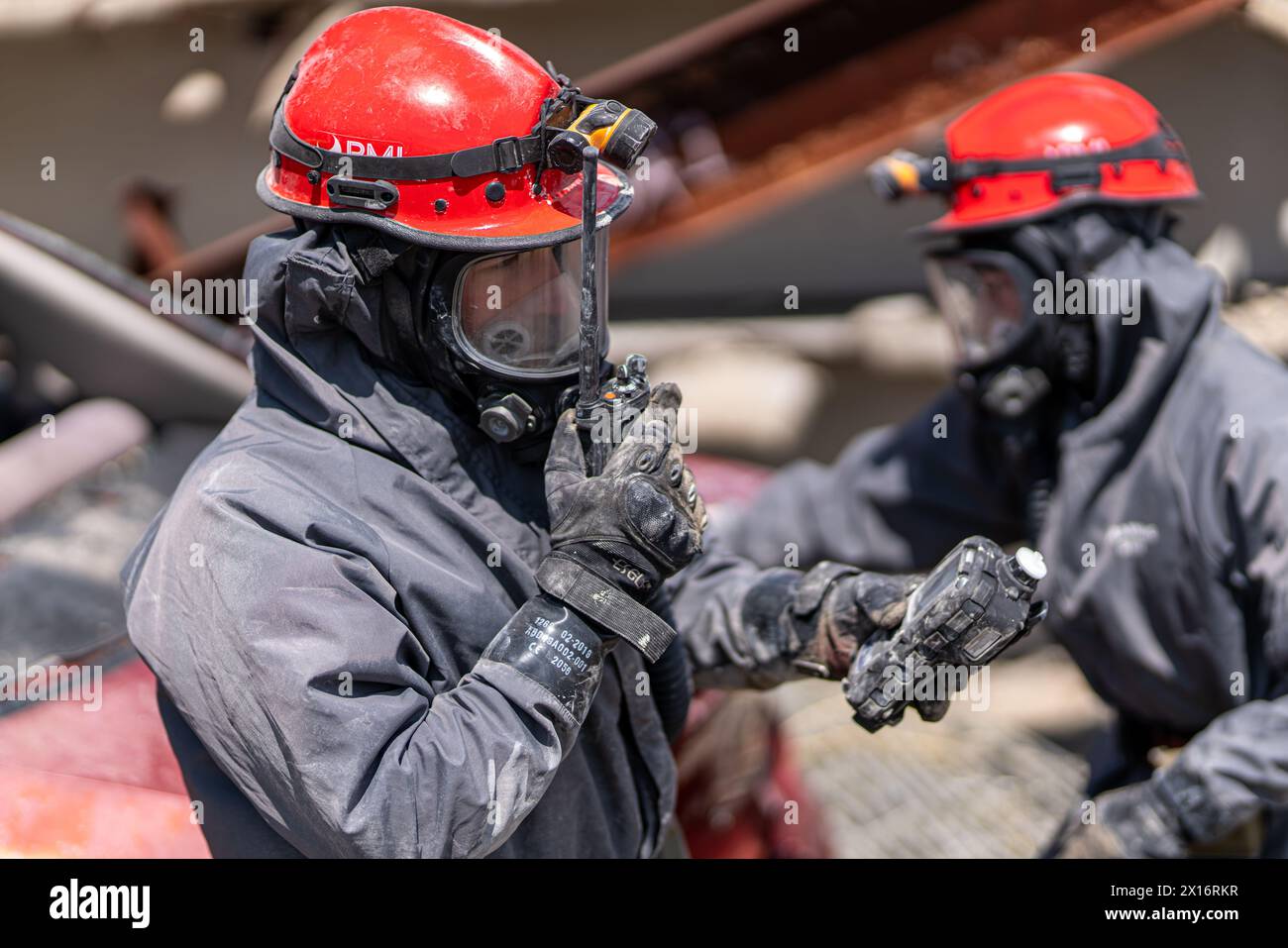 Two men in protective gear are standing next to each other. One of them ...
