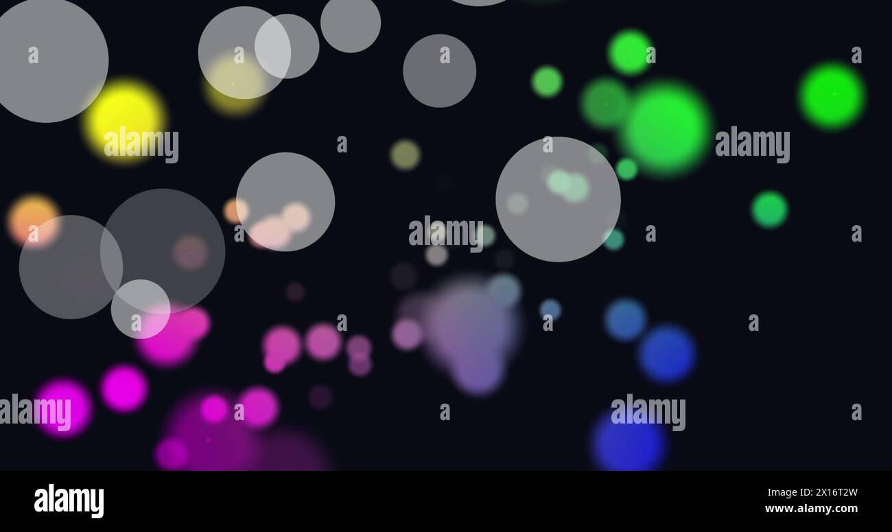 Image of white and colorful spots of light floating against black ...