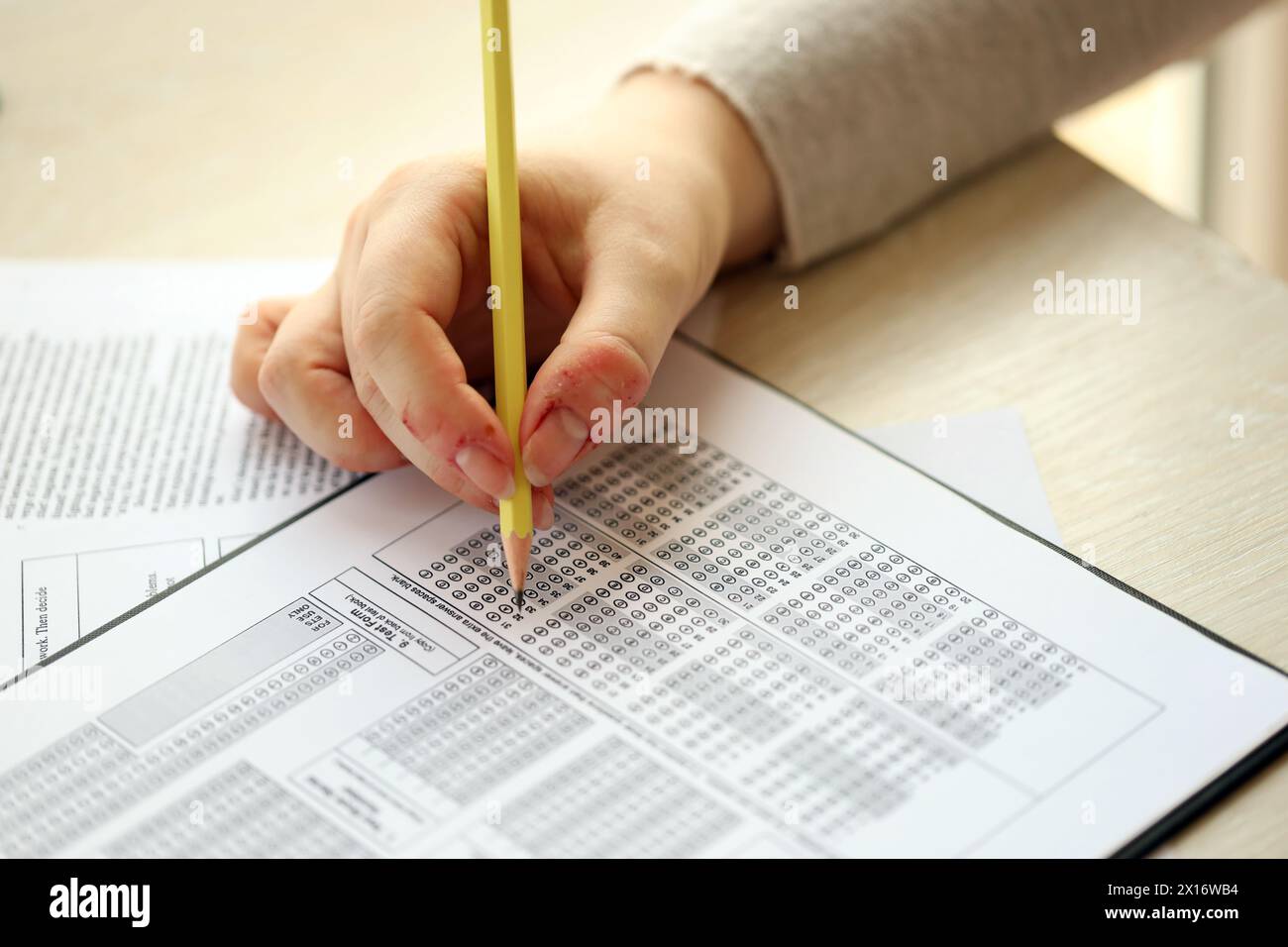 Female student hands testing in exercise and taking fill in exam paper ...