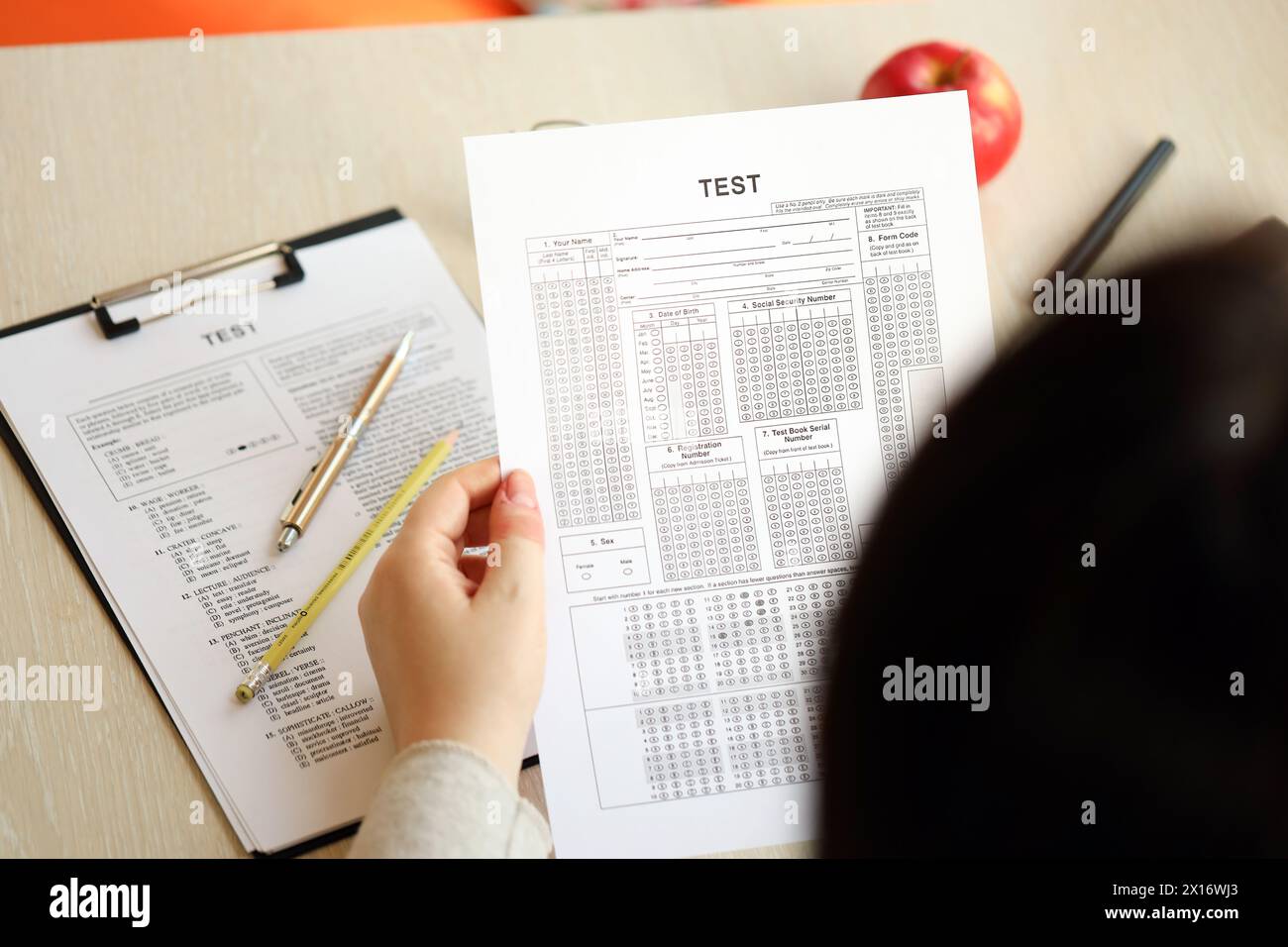 Female student hands testing in exercise and hold exam paper sheet with ...