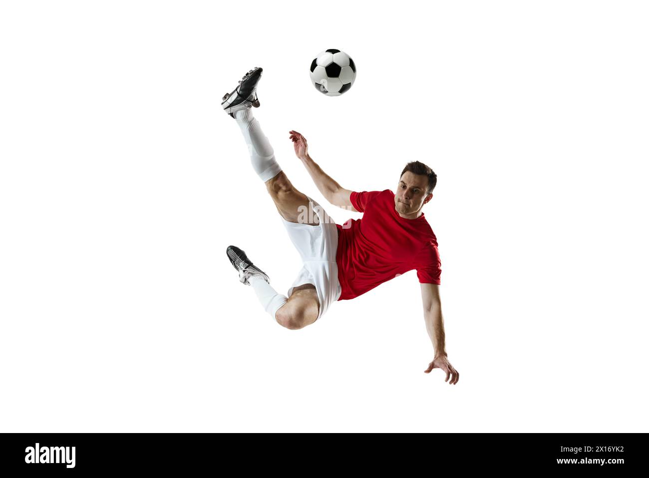 Competitive man, football player in motion with ball, hitting in a jump ...