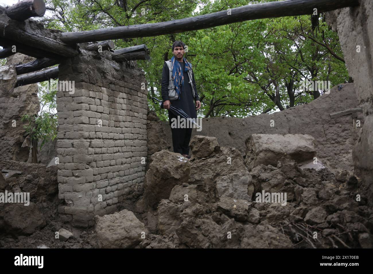 Parwan. 15th Apr, 2024. A man stands on the ruins of a dwelling ...