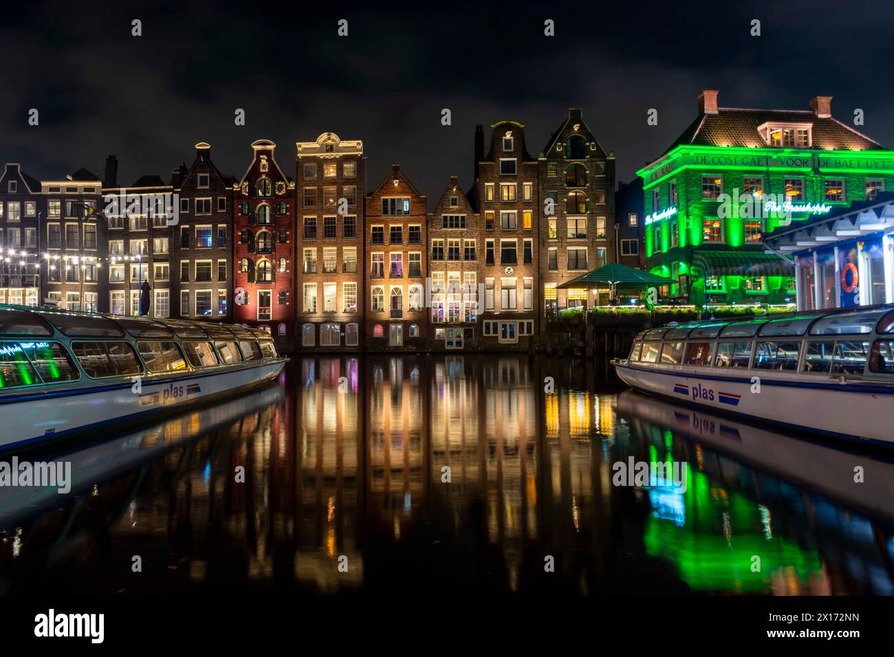 Dancing houses on Amsterdam Damrak canal at night Stock Photo - Alamy