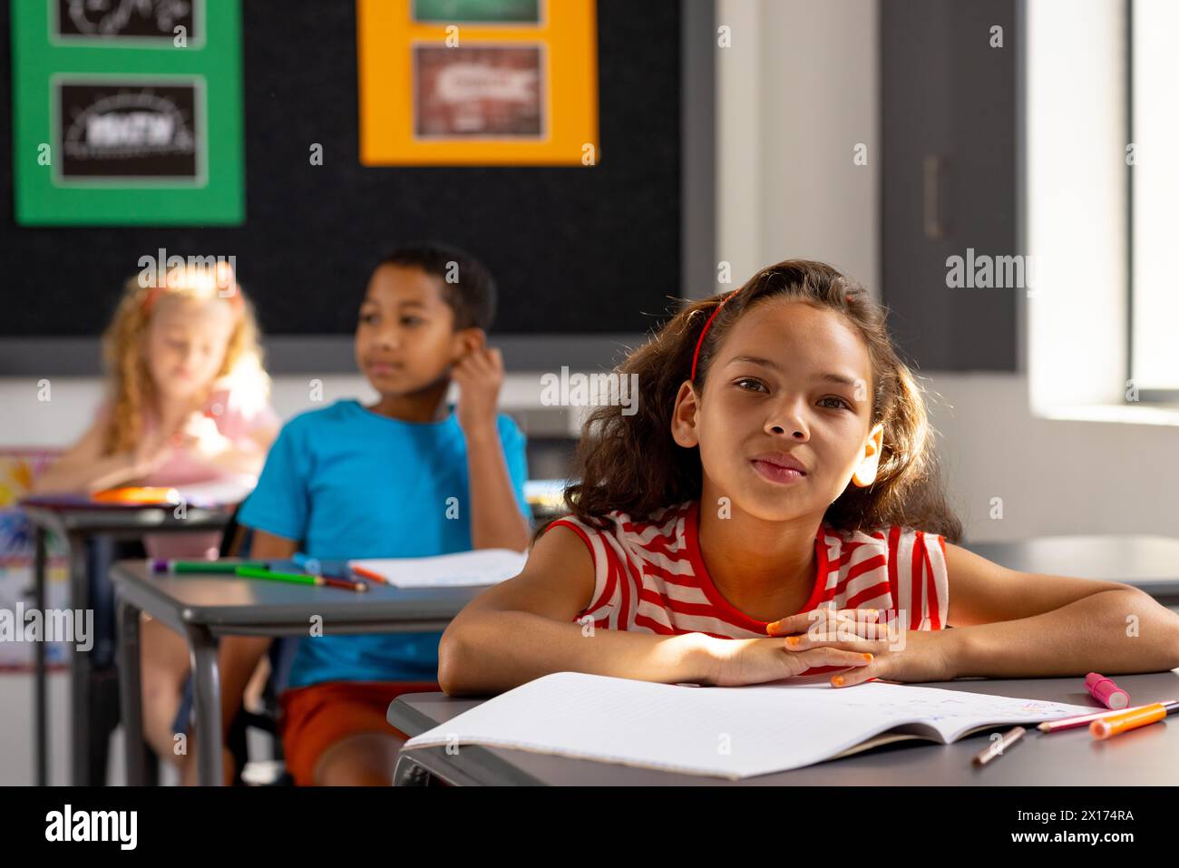 In school, diverse group of young students focusing on their work in ...