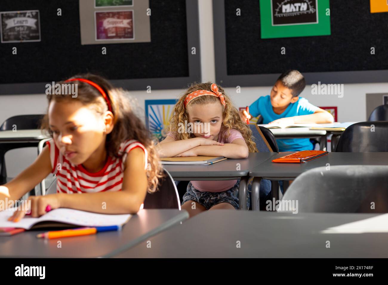 In school, diverse group of young students focusing on their tasks in ...