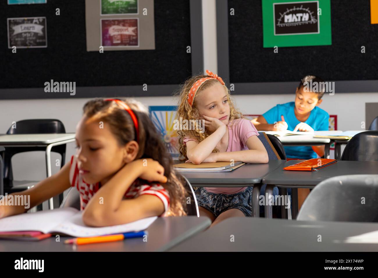 In school, diverse young students focusing on their tasks in the ...