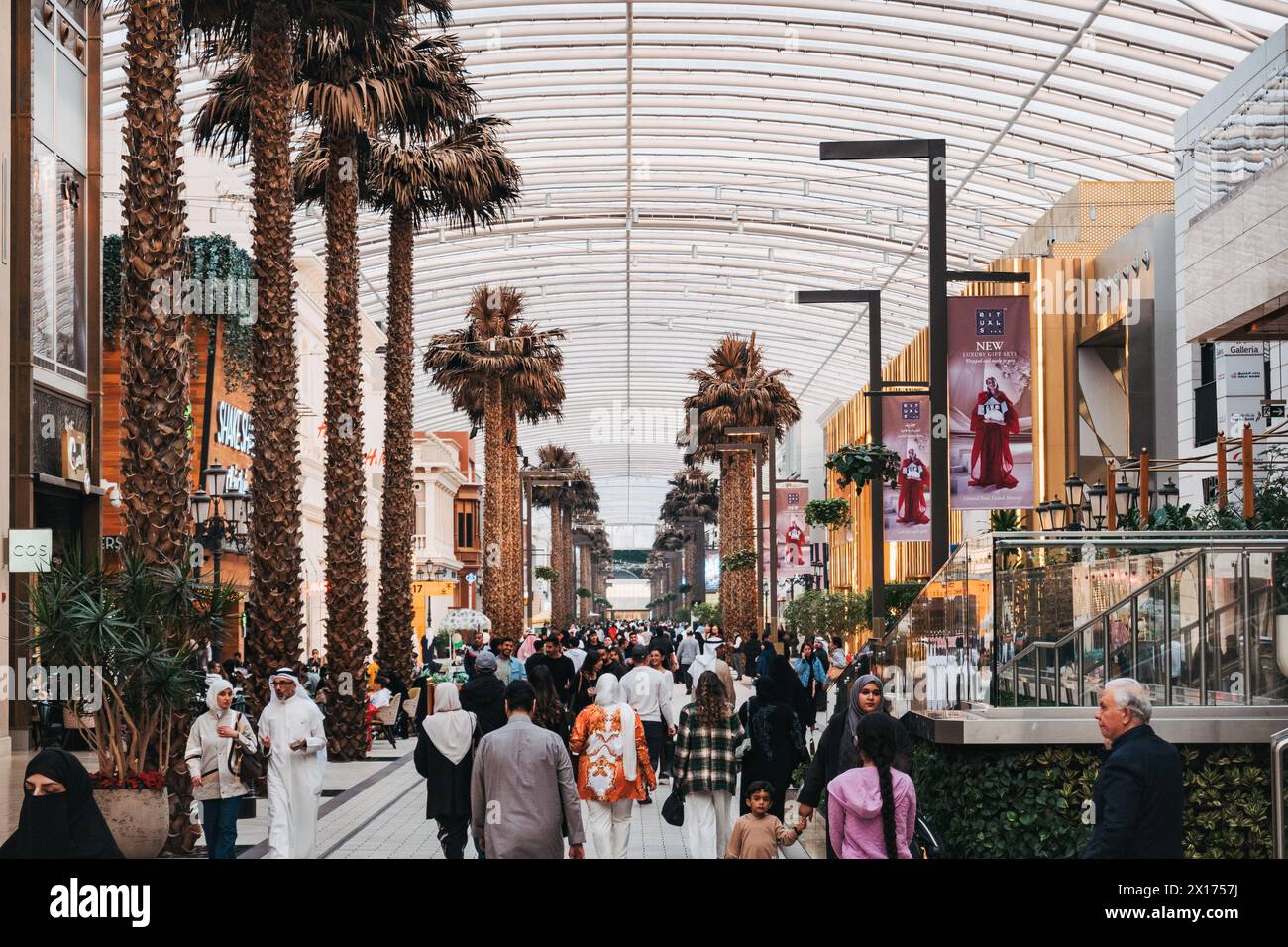 palm trees line a busy street inside The Avenues, the largest shopping ...