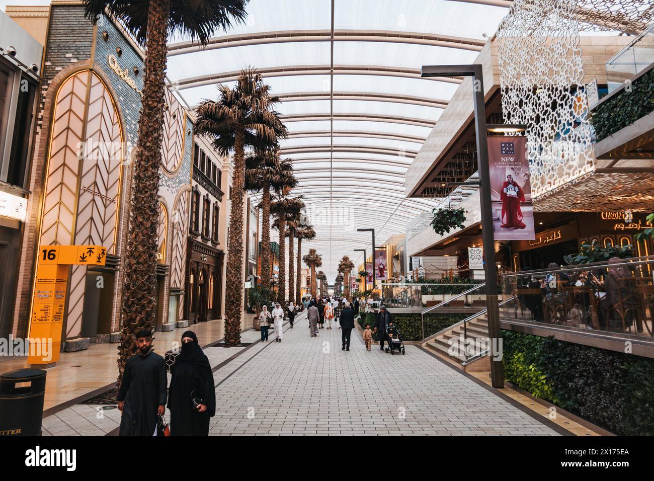 palm trees line a busy street inside The Avenues, the largest shopping ...