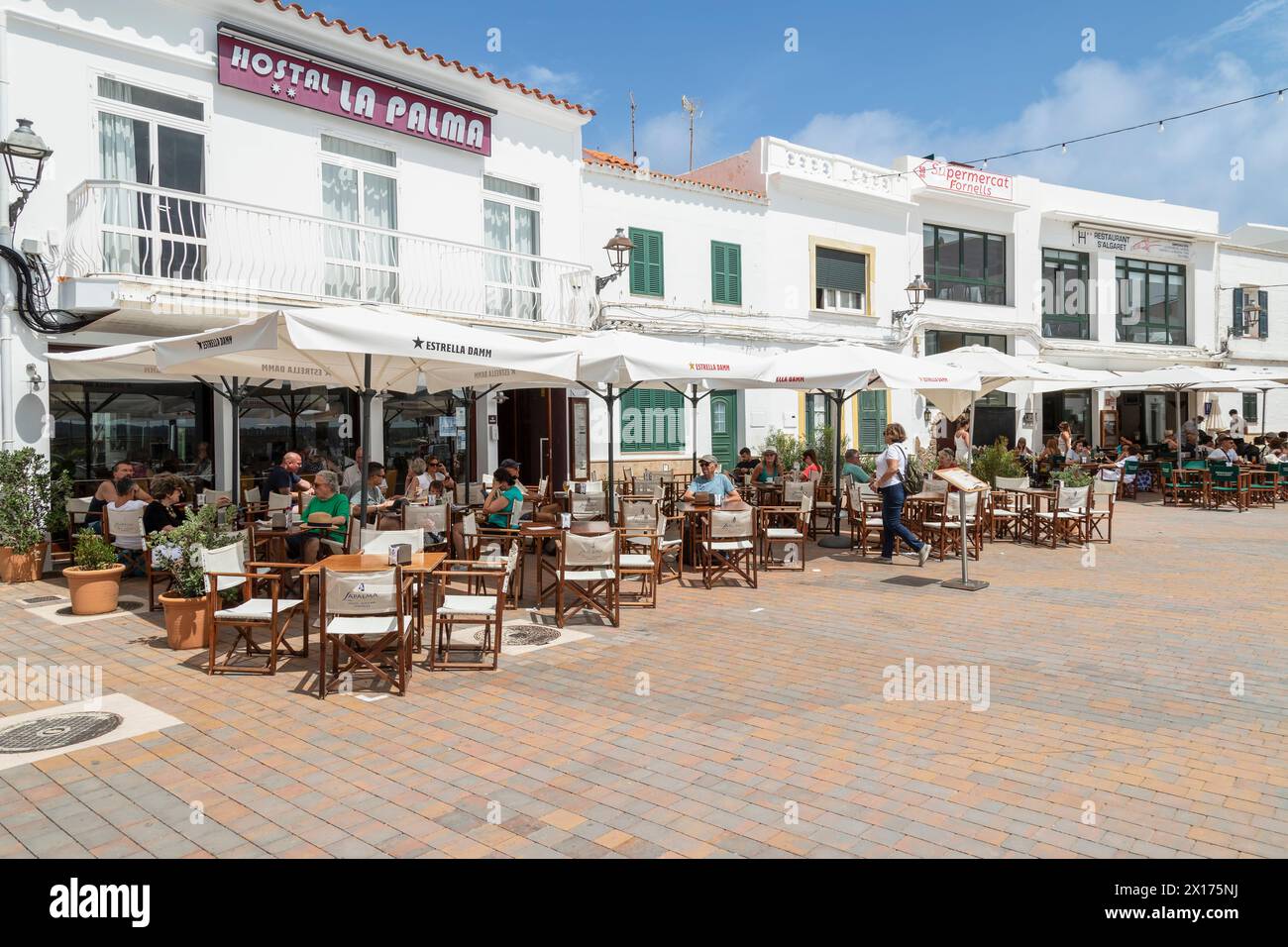 People enjoy the terrace in the center of the coastal town of Fornells ...