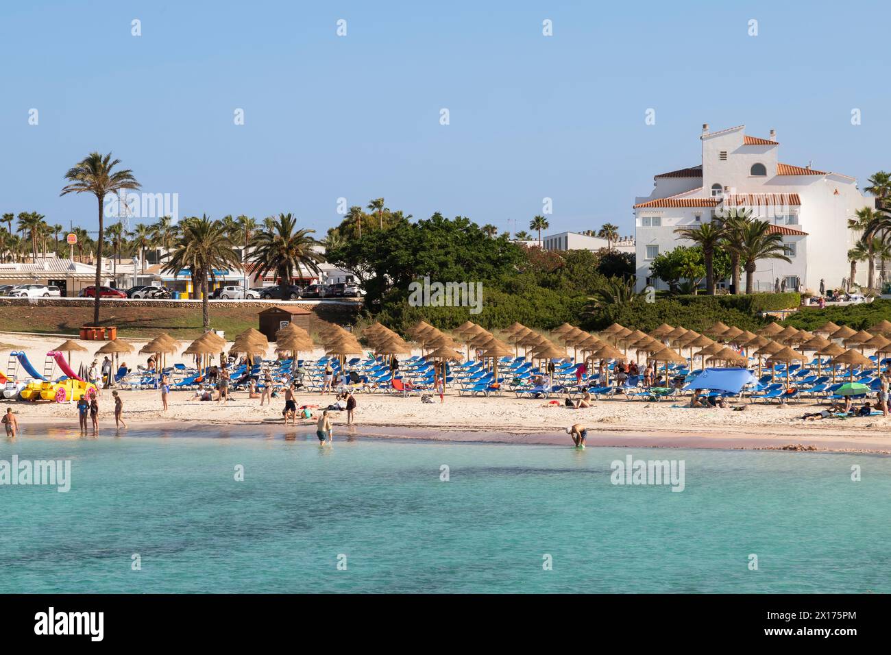 Tourists enjoy the sea water in the resort of Cala en Bosc on the ...