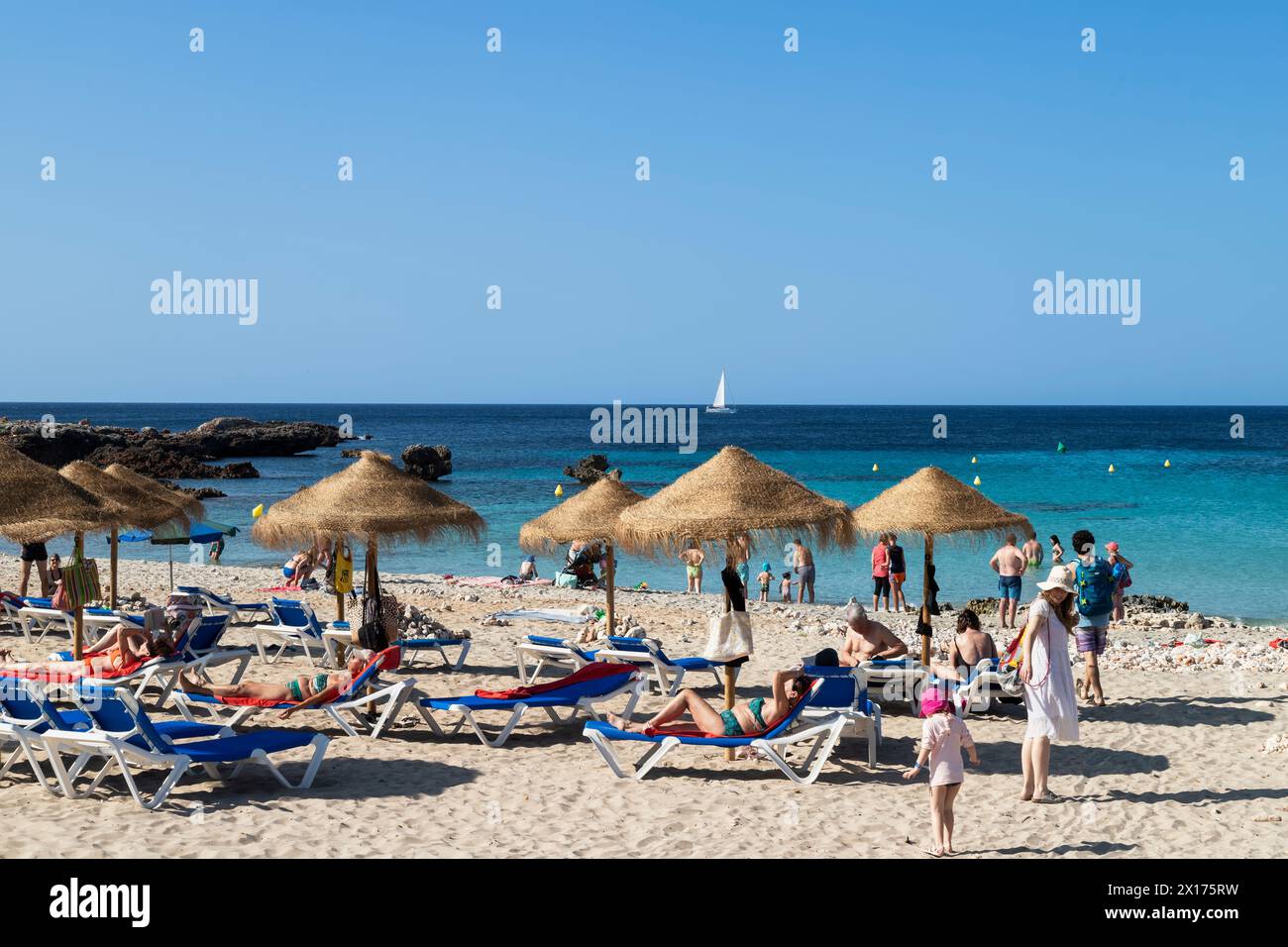 Tourists enjoy the sea water in the resort of Son Xoriguer near Cala en ...