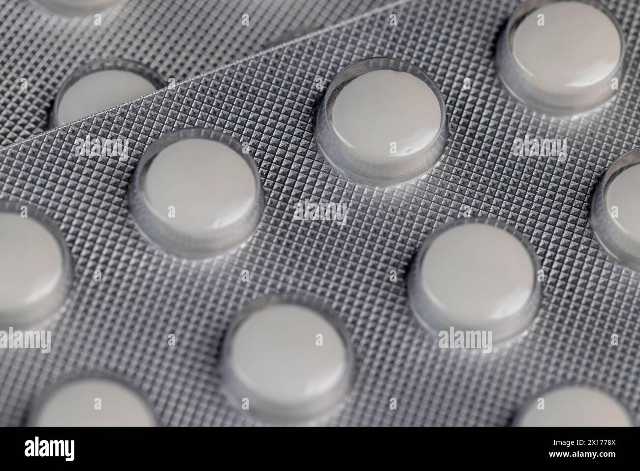 white tablets packed in a blister close-up, individually packed in ...