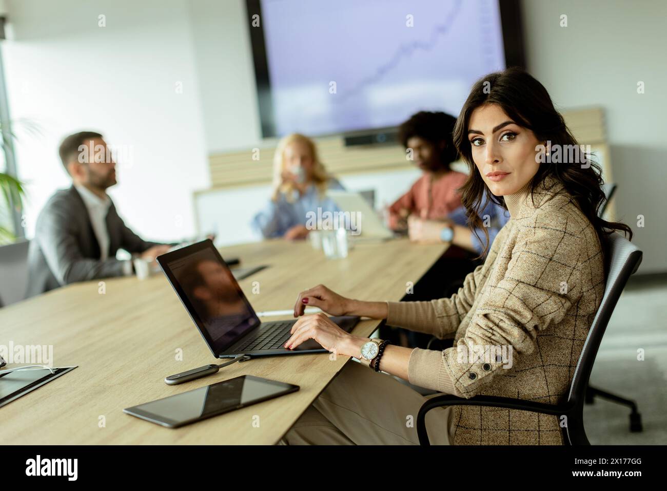 Confident businesswoman engages in a meeting, her smile reflecting ...