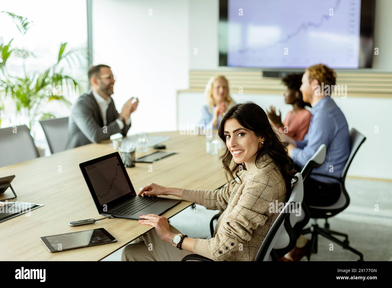 Confident businesswoman engages in a meeting, her smile reflecting ...