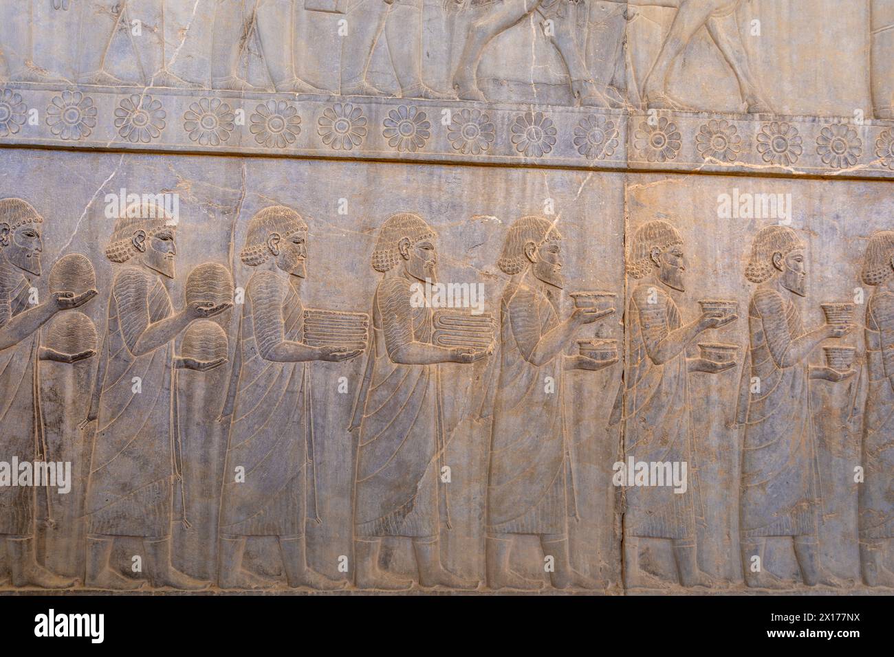 Detailed stone engravings depicting people and animals in motion. A ...