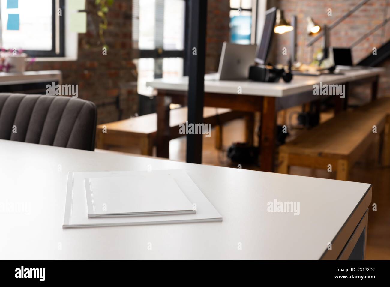 A white book resting on table in a modern office space Stock Photo - Alamy