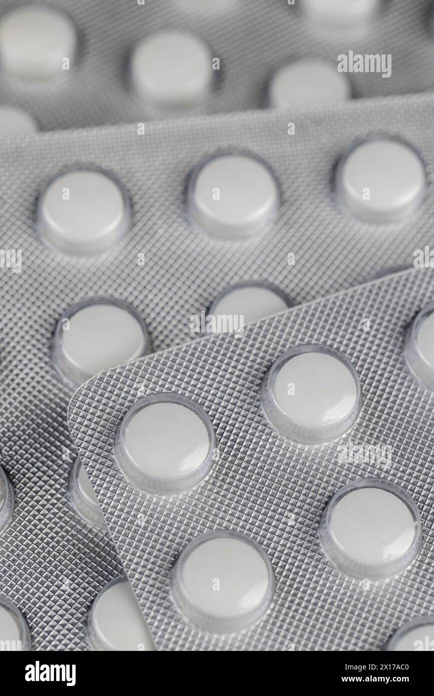 white tablets packed in a blister close-up, individually packed in ...