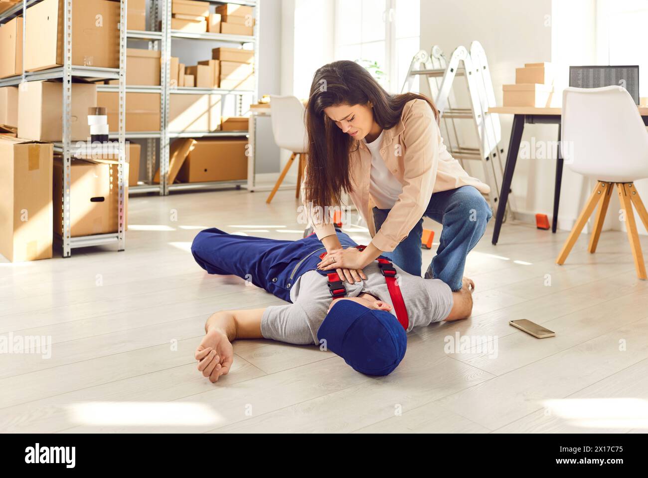 Woman giving first aid to Injured unconscious worker lying on the floor ...