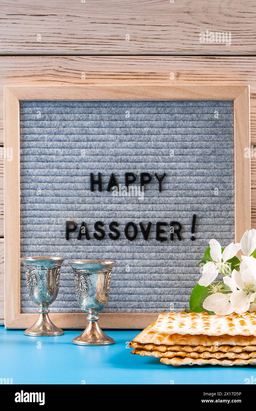 Happy Passover. Metal wine glasses and traditional Jewish matzo bread ...