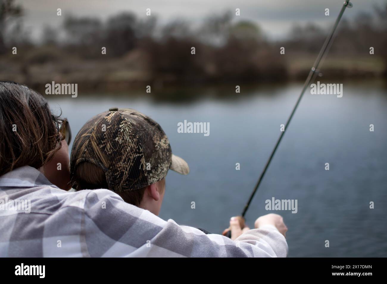 Learning to fish, a mother teaches her son how to fish, on a family ...