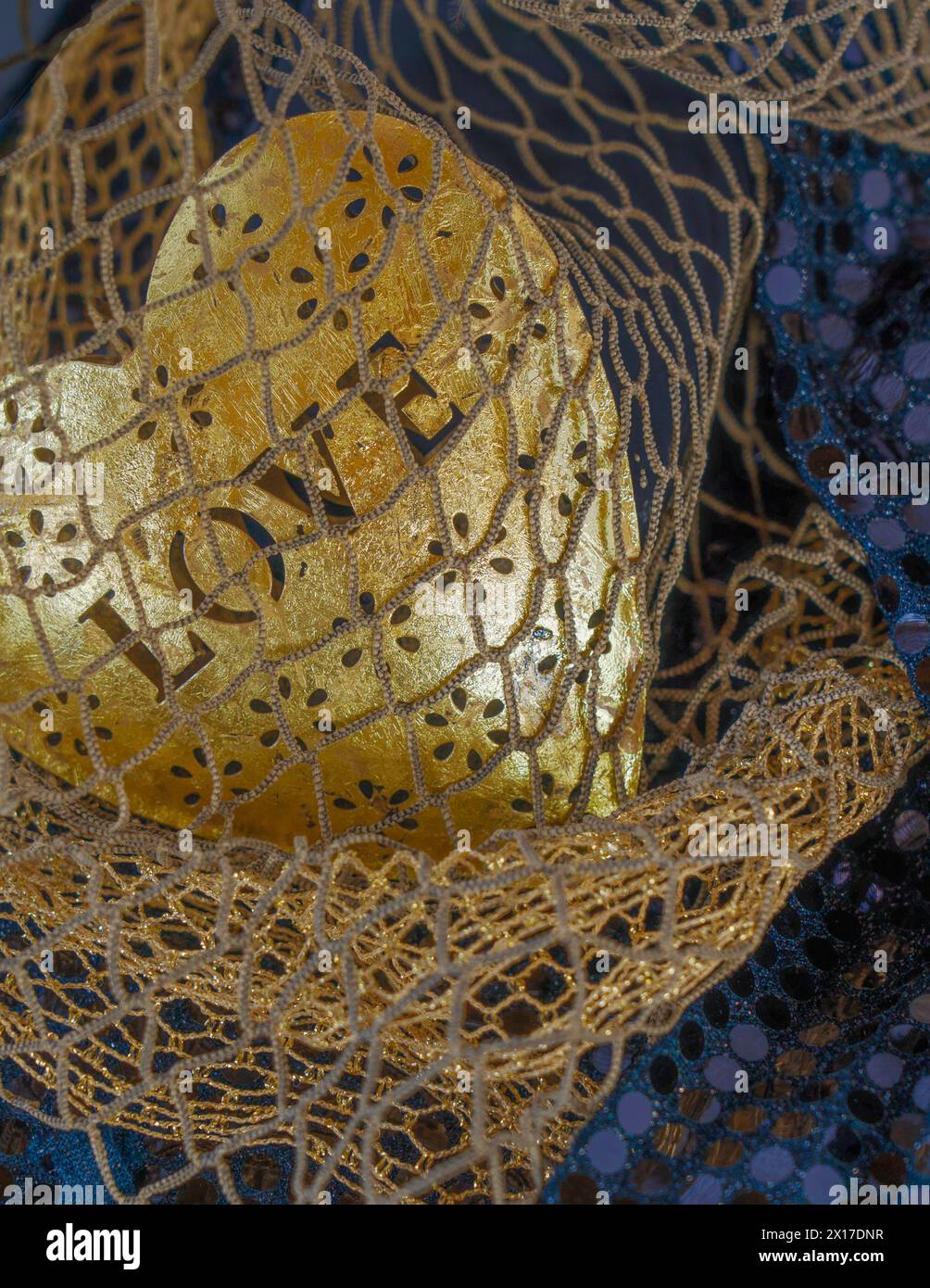 Gold fish net captured metal heart with LOVE sign in black is decorated ...