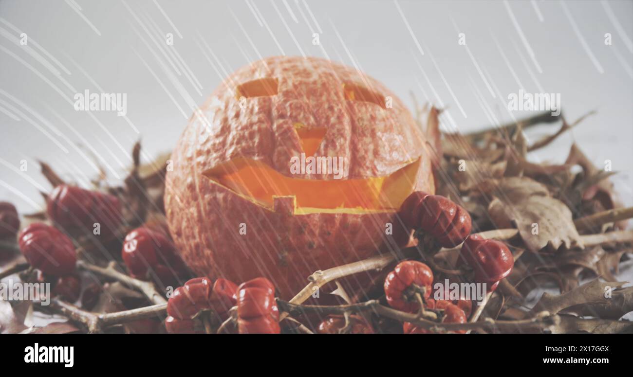 White light trails falling over halloween carved scary pumpkin against ...