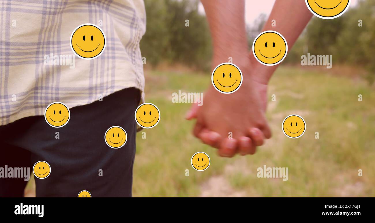 Image of multiple smiling face emoji floating against mid section of ...