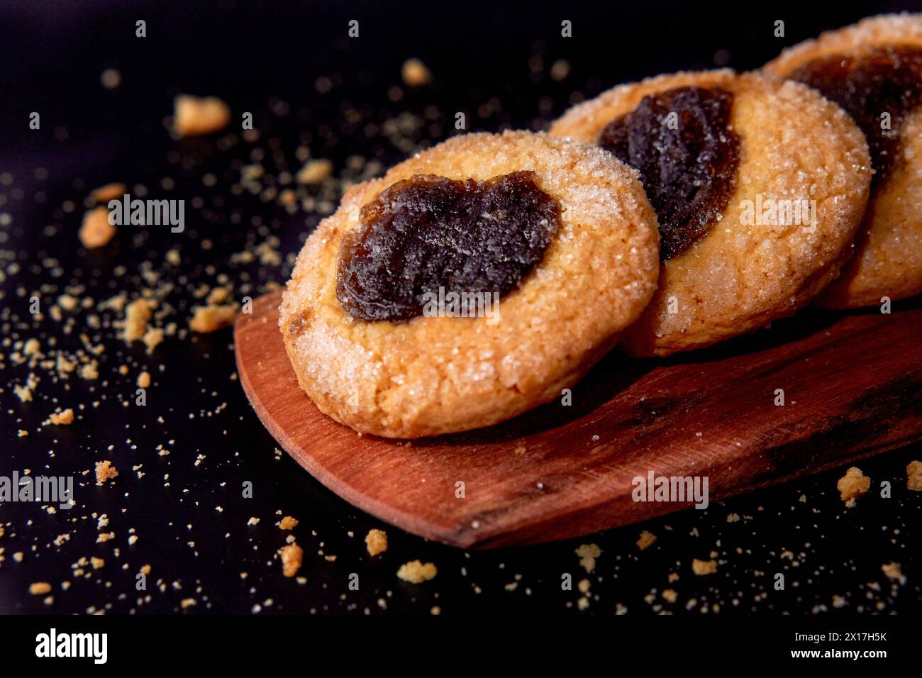 homemade cookies with quince jelly on a rustic wooden board with black ...
