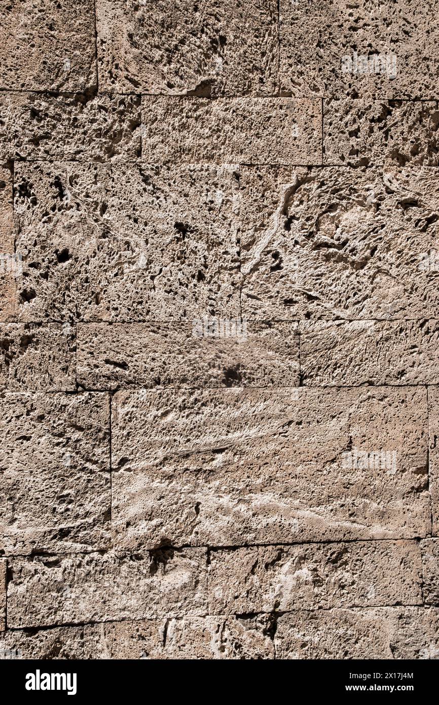 Stone wall of limestone bricks with spongy surface closeup as stone ...