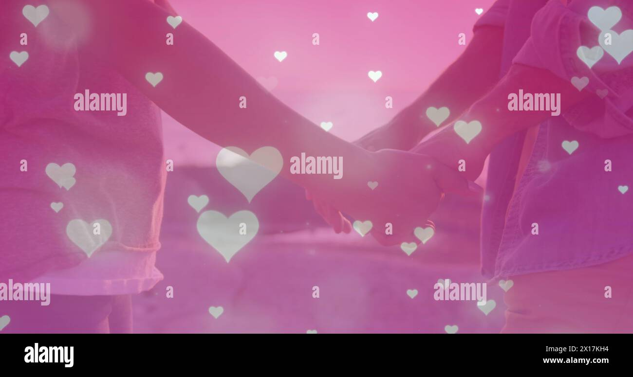 Image of multiple heart icons falling over mid section of couple ...