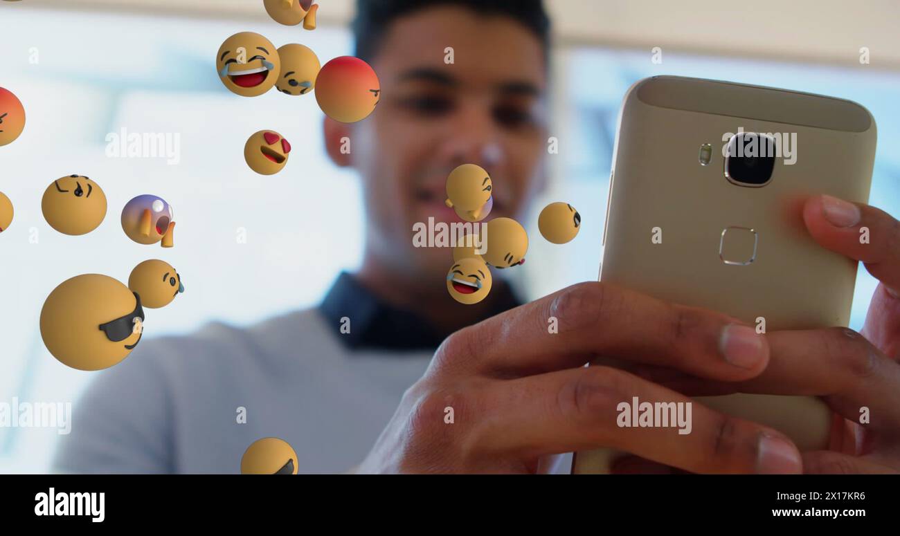 Image of multiple face emojis floating over biracial man using ...