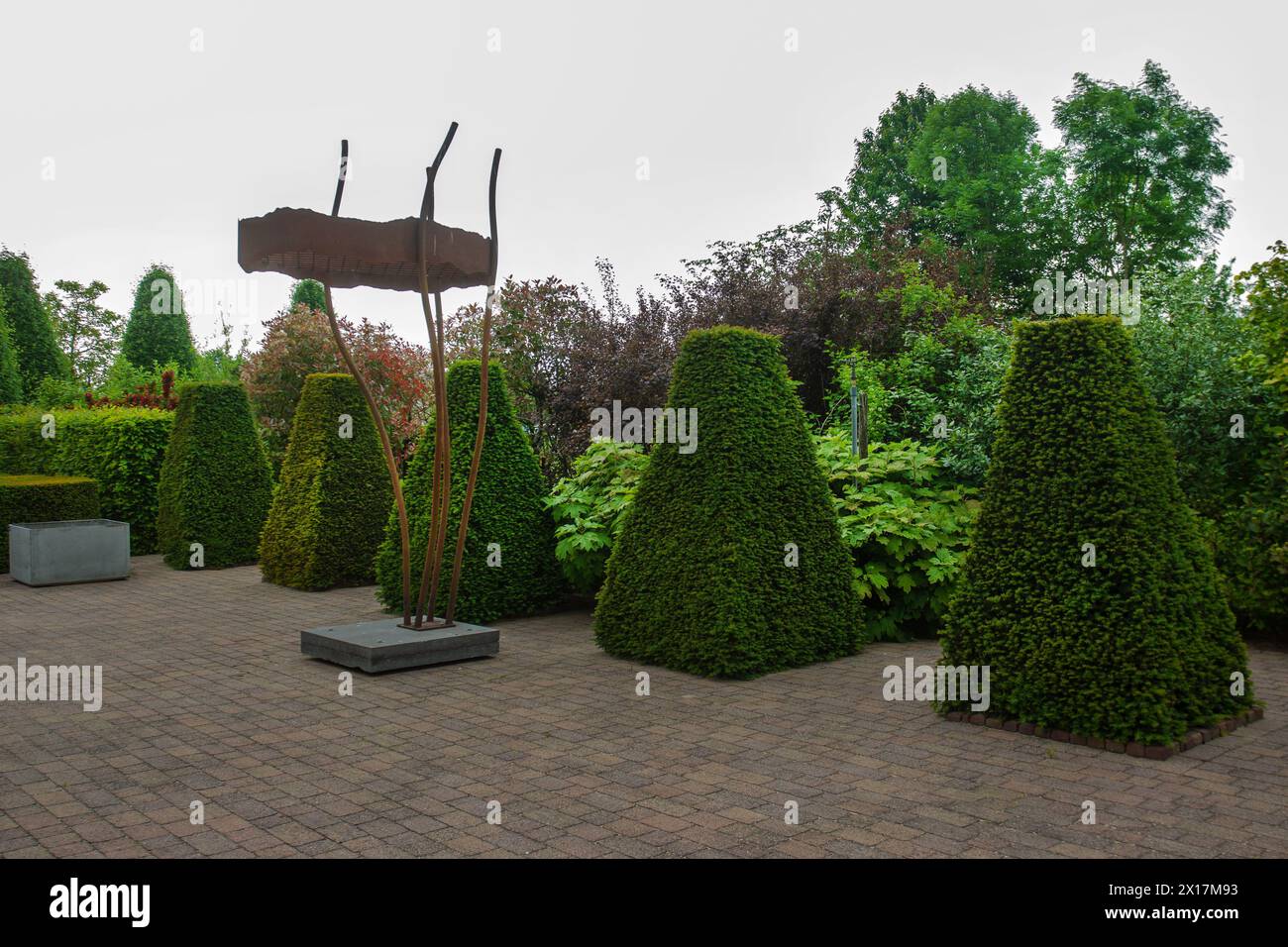 Awegarden with funny metal construction and topiary bushes (yew tree ...