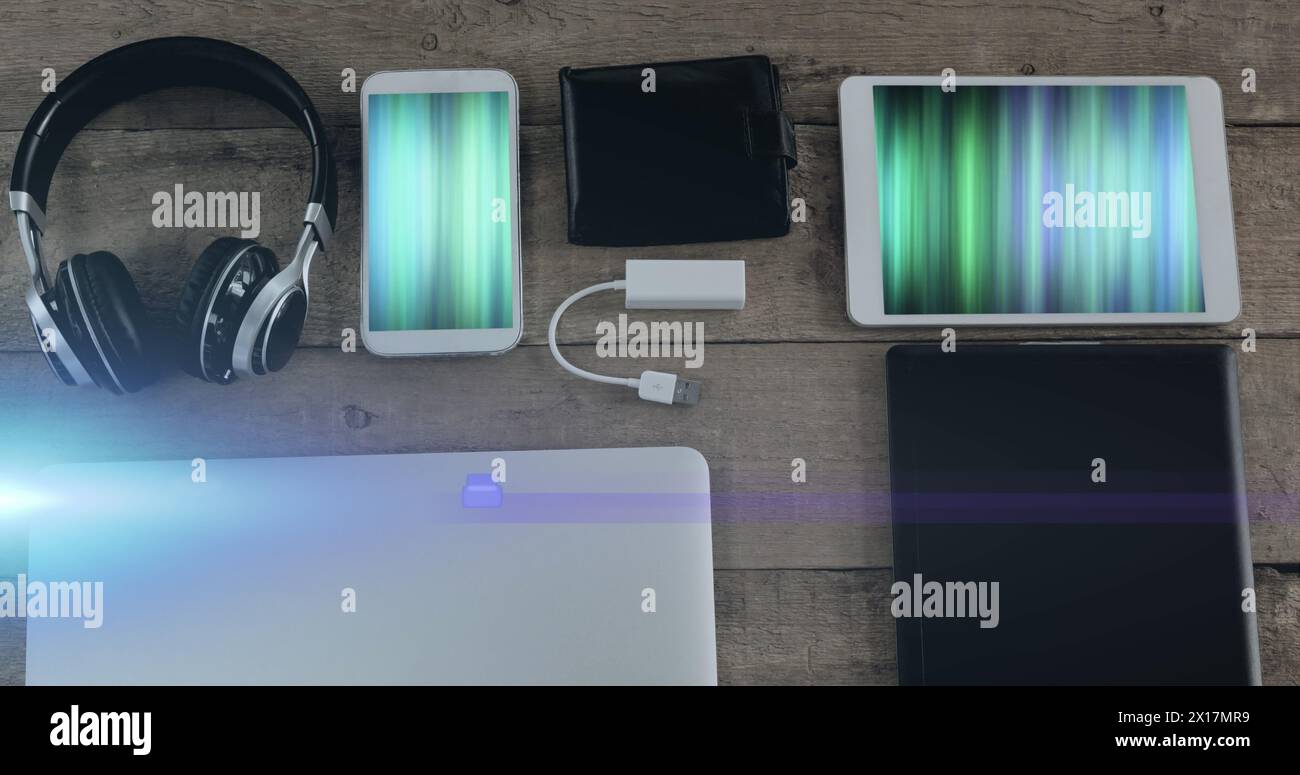 Image of light trails over technological devices with colorful moving ...