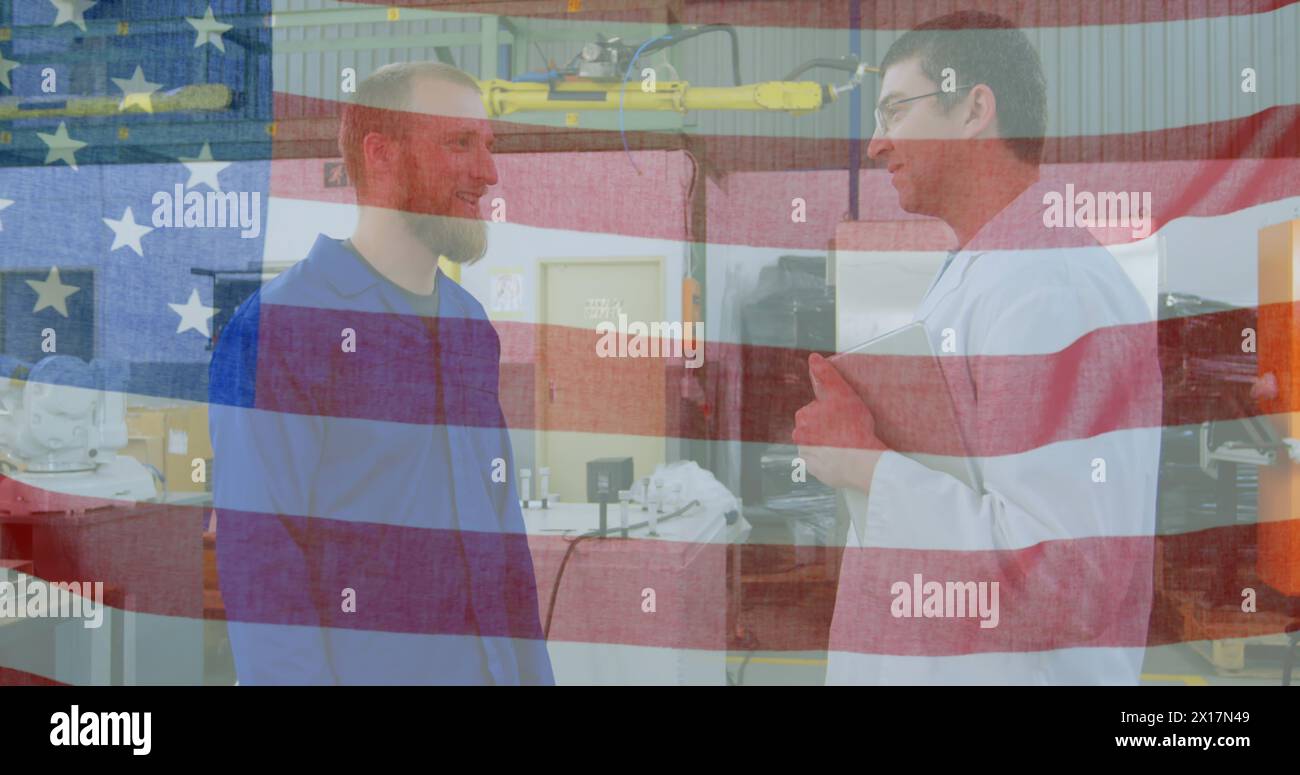 Image of American flag waving over two men working and talking factory ...