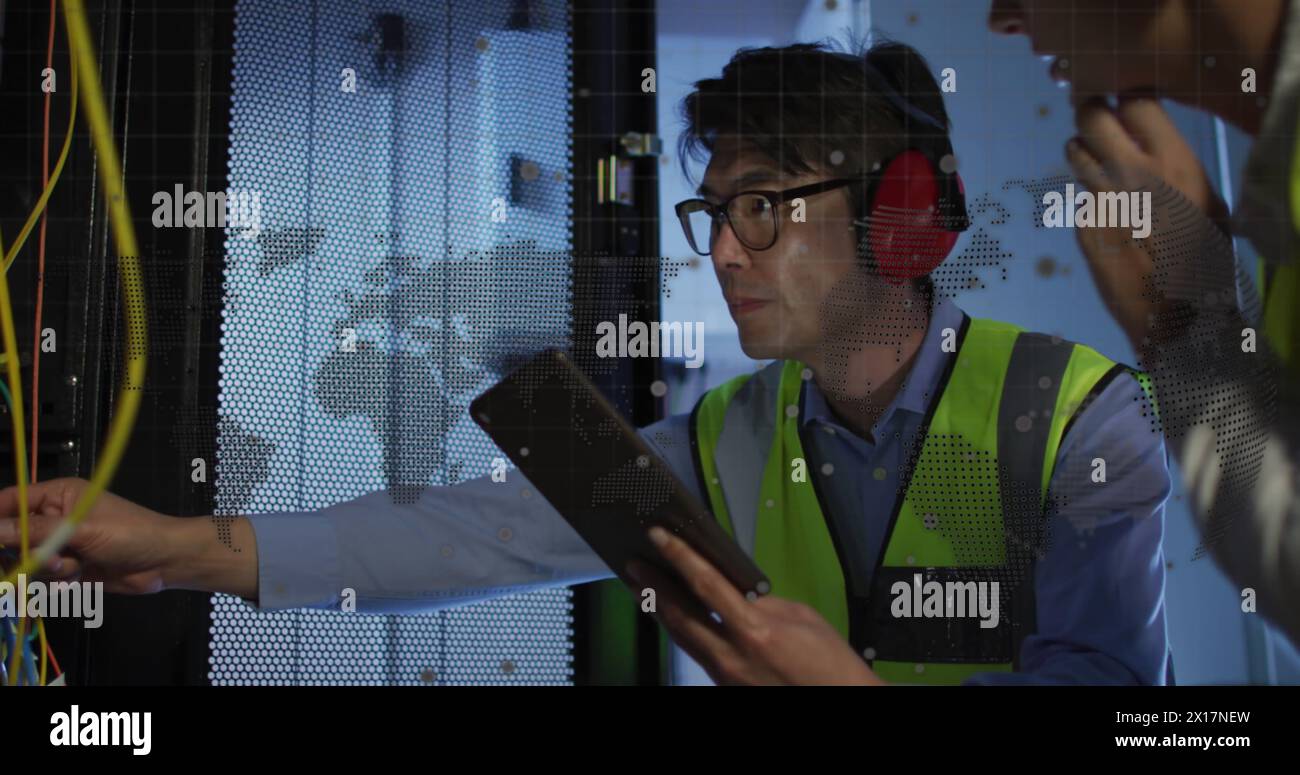 Spinning globe and world map against diverse male and female engineers ...