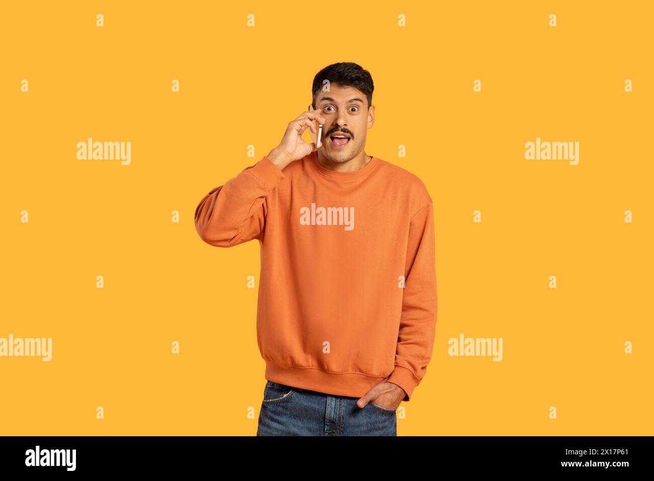 Guy talking on phone with shocked expression Stock Photo - Alamy