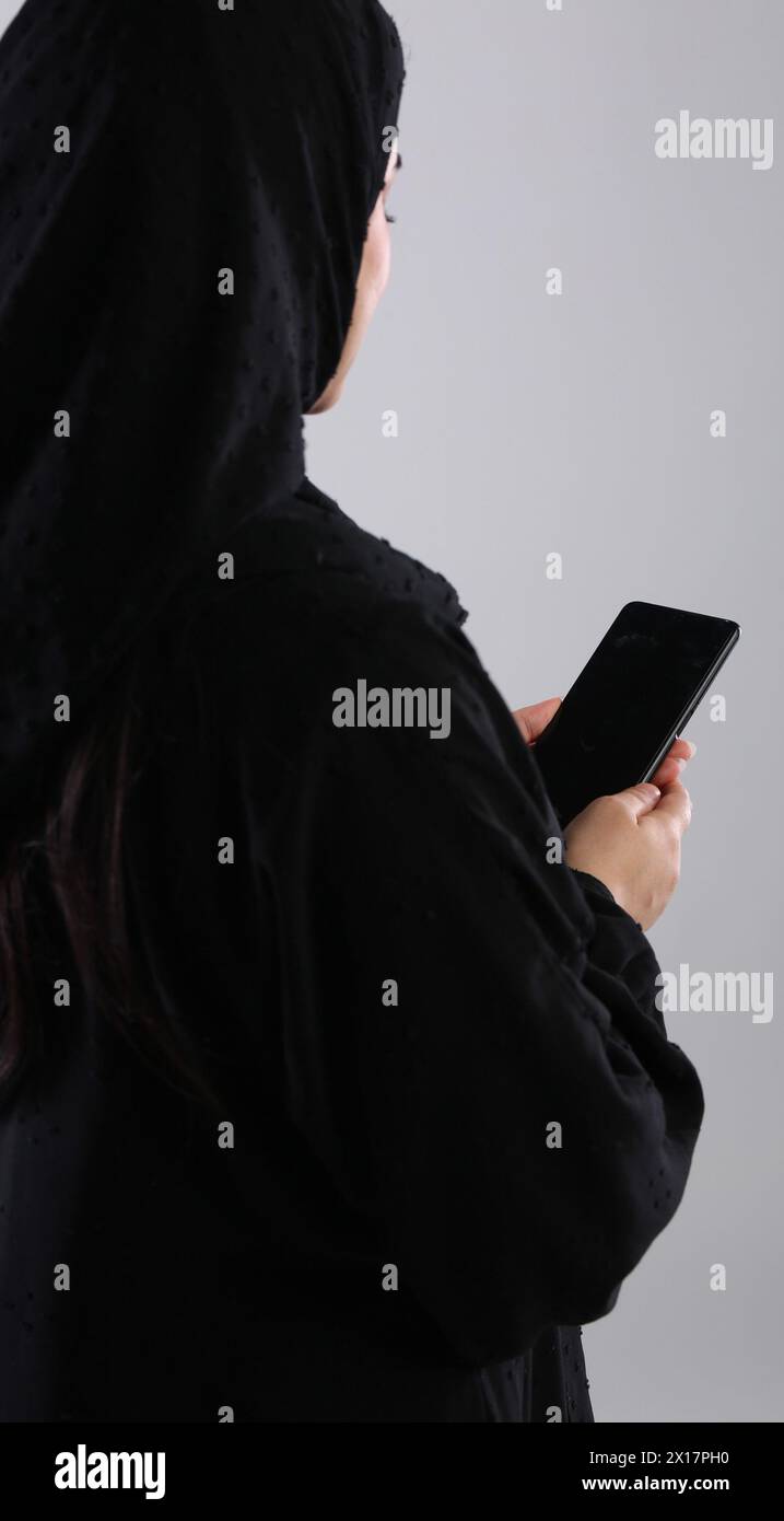 Saudi arabian woman in hijaab standing with mobile in hand Stock Photo ...