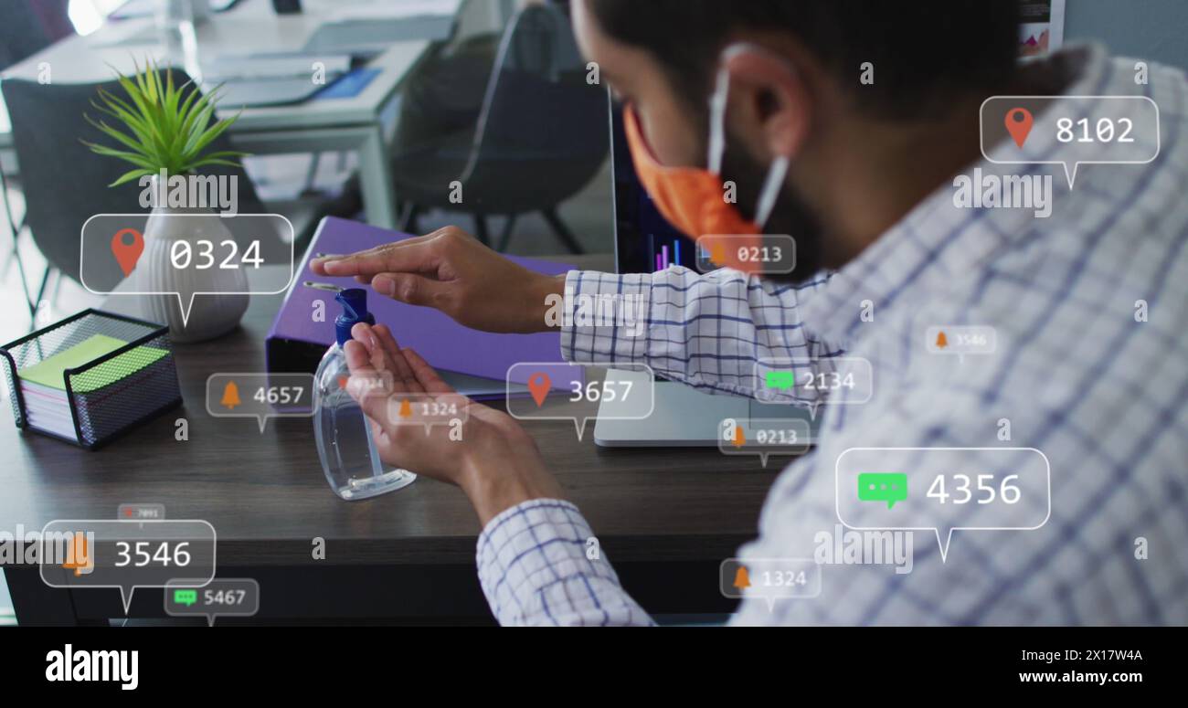 Image of social media icons over biracial man wearing face mask using hand sanitizer at office ...