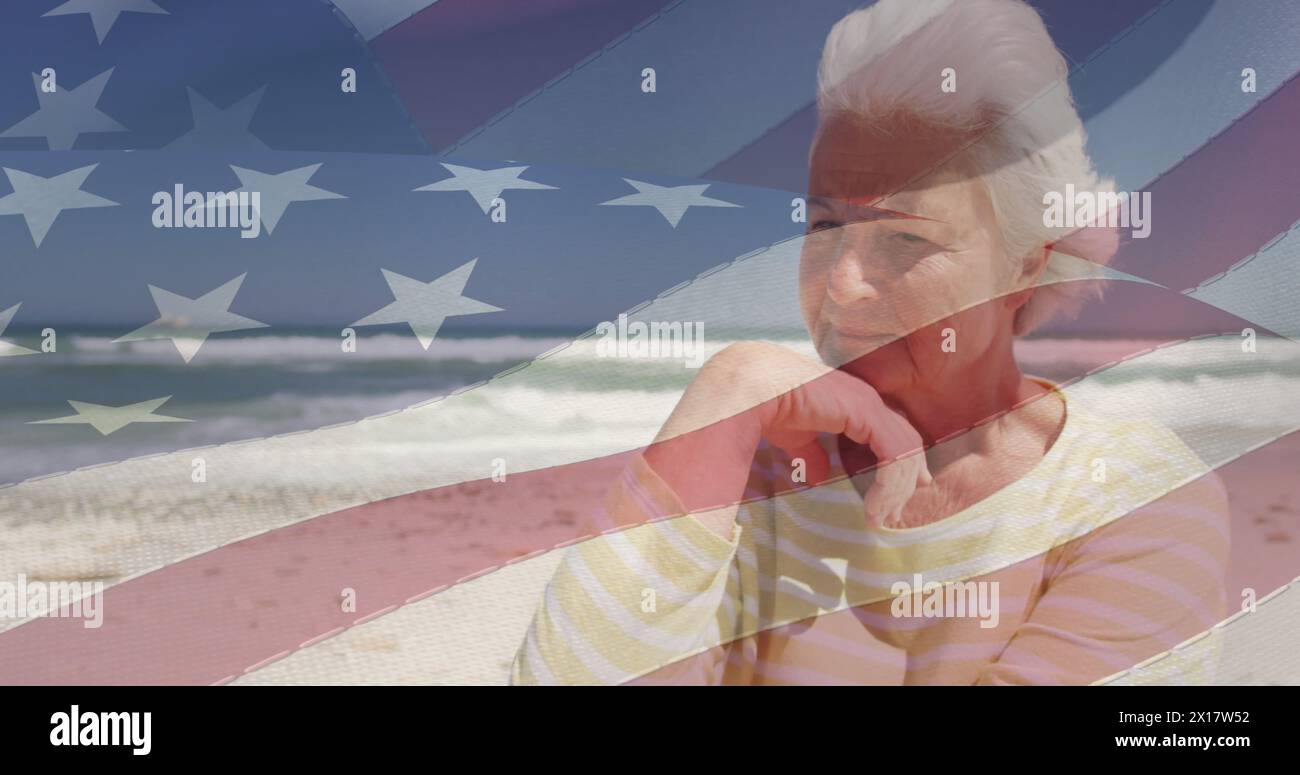 Image of senior caucasian woman sitting on beach over flag of united ...