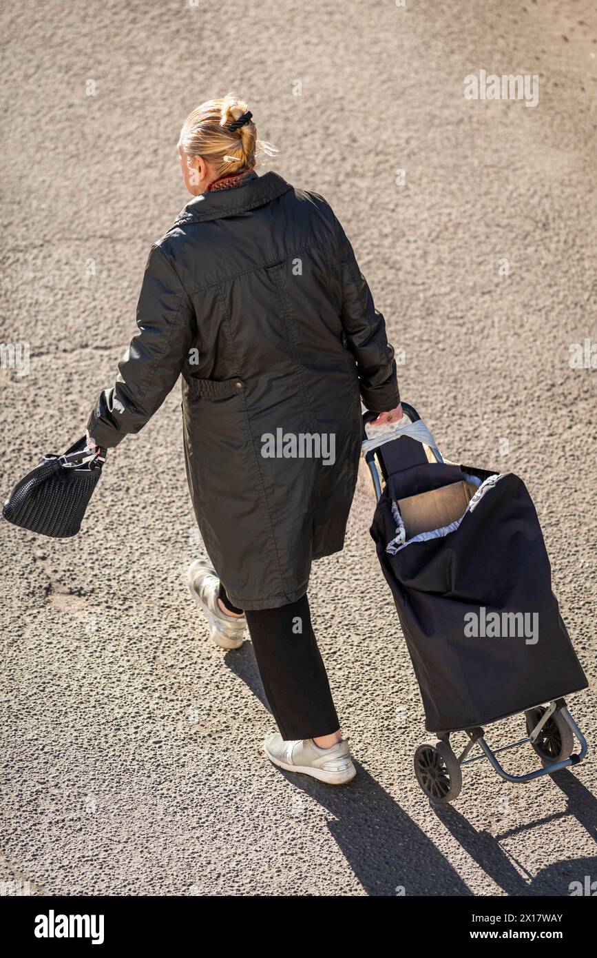 Woman pulling shopping cart hi-res stock photography and images - Alamy